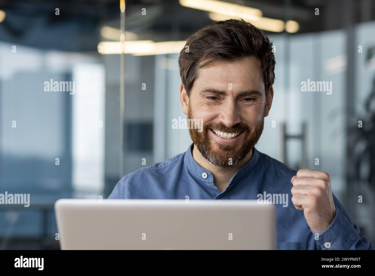 Joyful male professional with beard in office setting, smiling while ...
