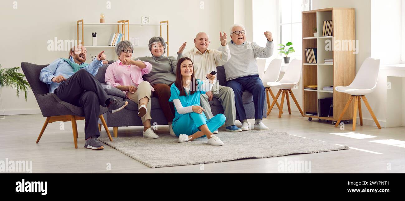 Group of senior people watching TV in retirement home together with ...
