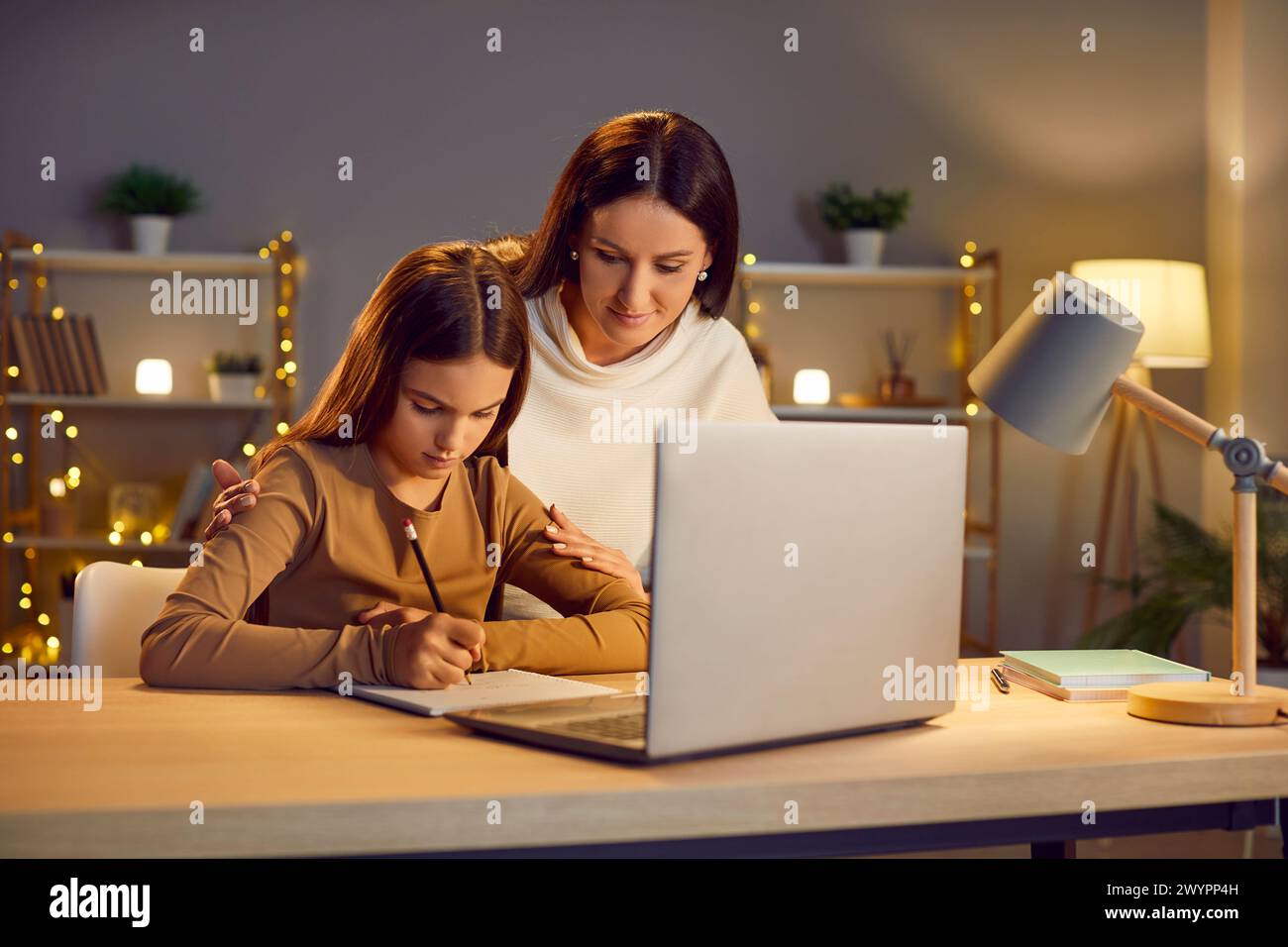 Mother and young daughter wtitting task, letter near laptop, family in ...