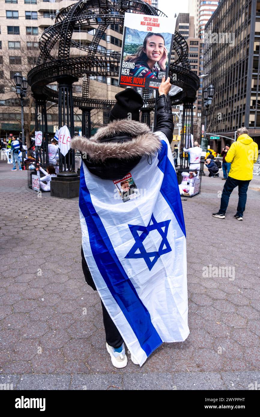A woman wrapped in an Israeli flag holds up a poster for hostage Noa ...