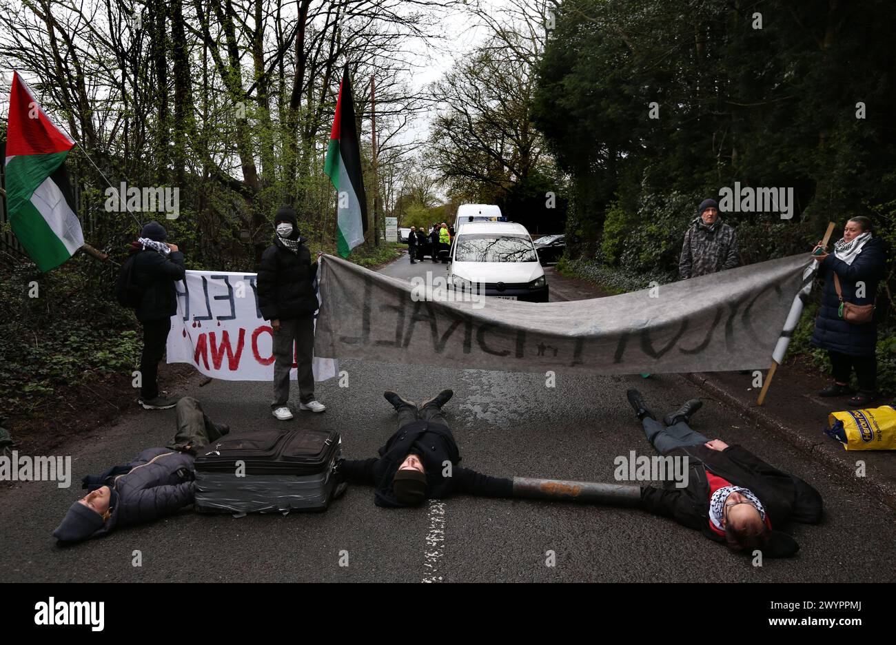 Three activists attached to lock-ons lay in the road, protected from ...