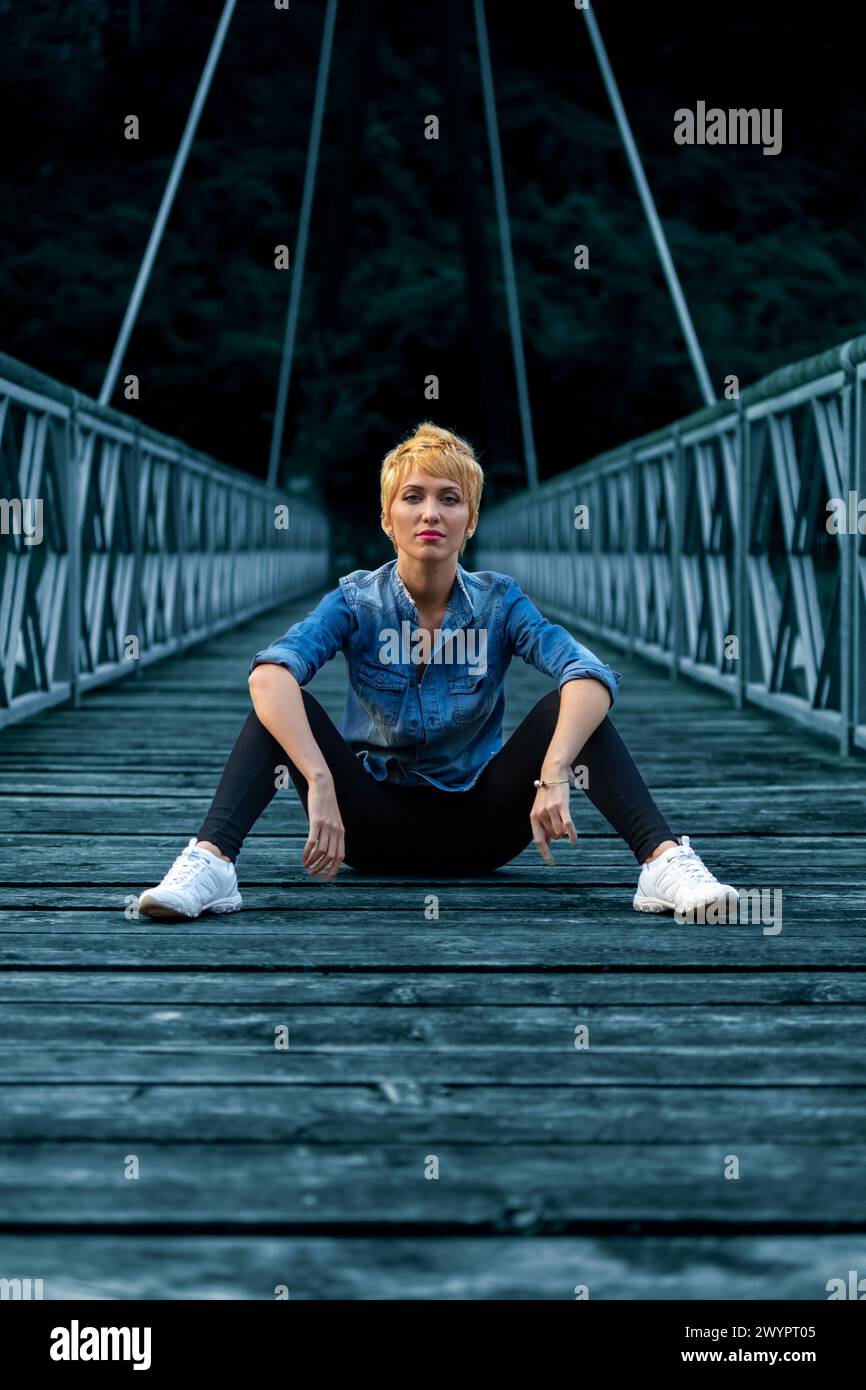 Surrounded by nature’s splendor, her relaxed pose on the bridge ...