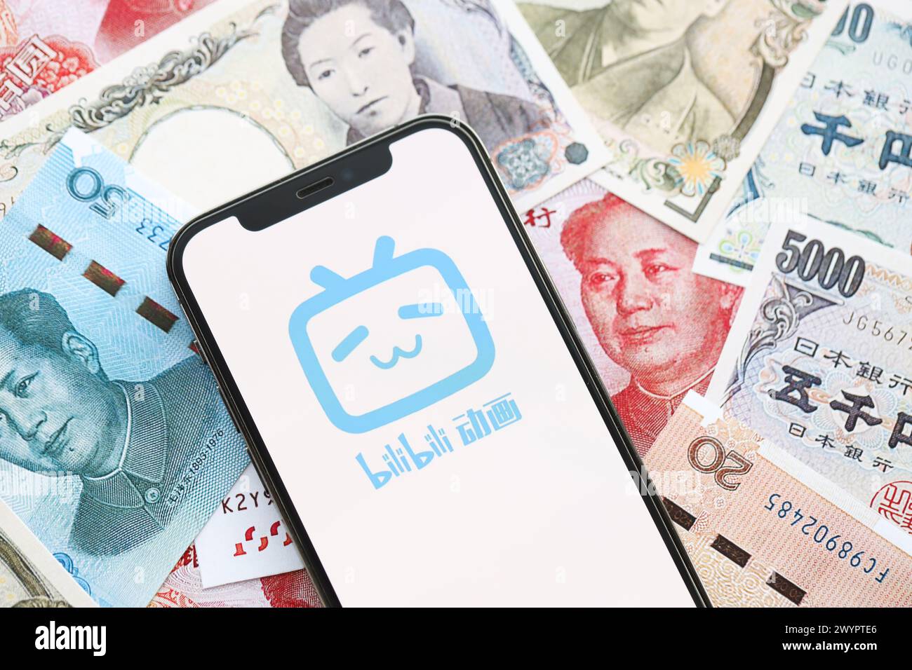 KYIV, UKRAINE - APRIL 1, 2024 Bilibili icon on smartphone screen on many asian money bills ...