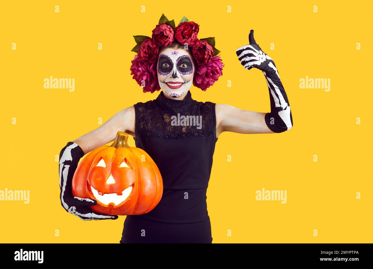 Happy funny Catrina girl holding Halloween jack o lantern, smiling and ...