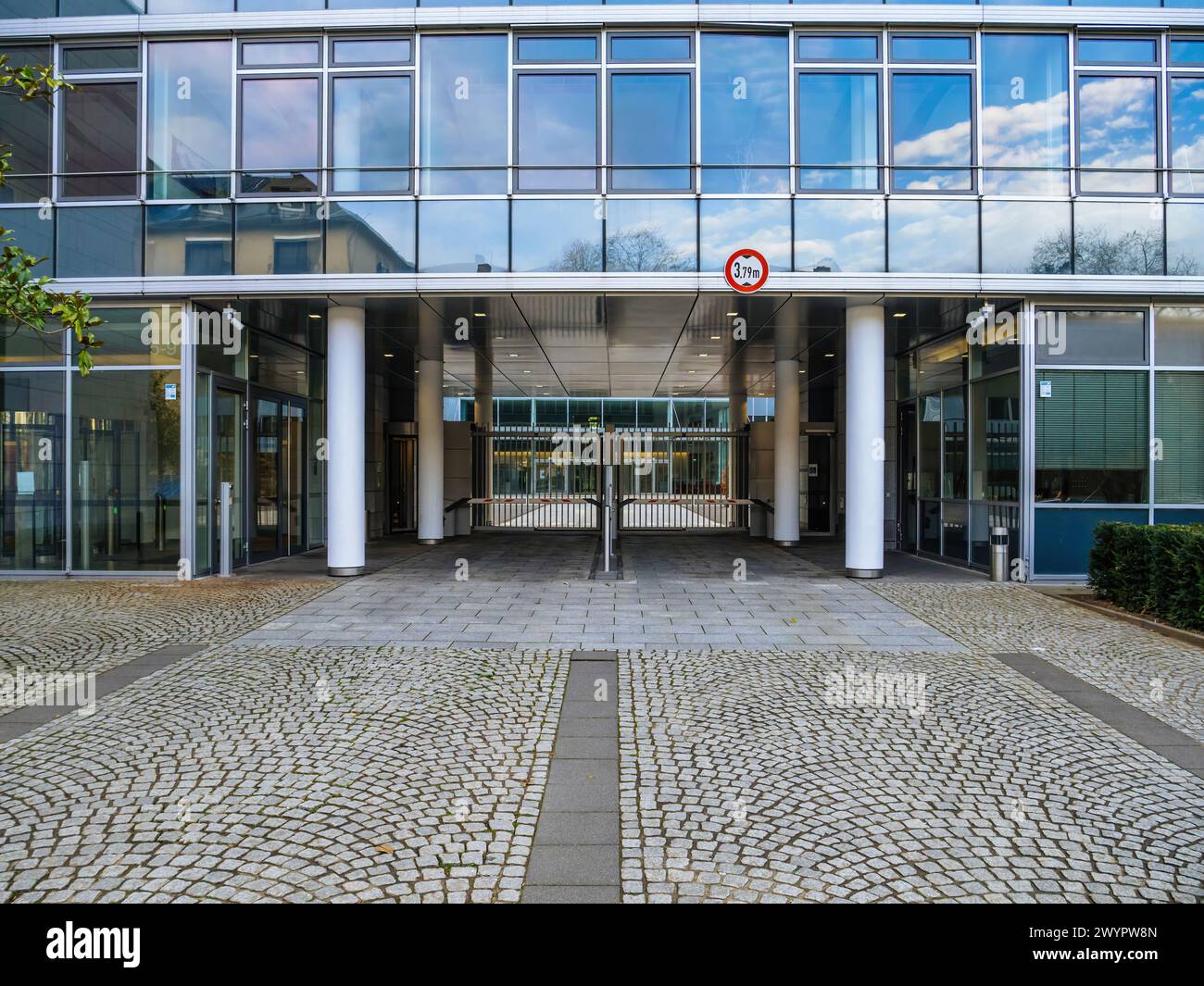 The main entrance of a large glass facade building features prominent ...