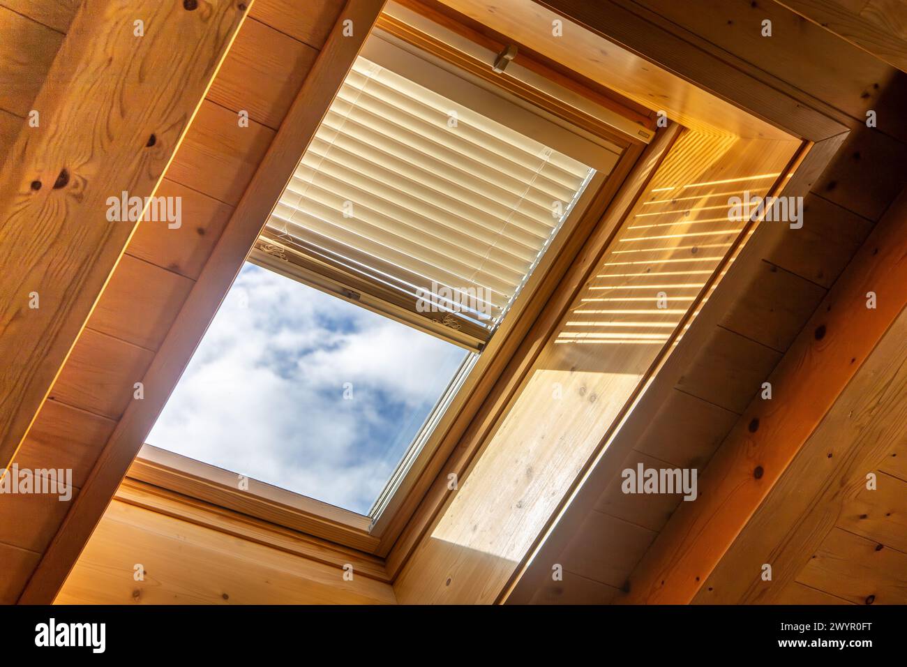 Interior view of a roof window with electronic blinds on a ceiling with ...