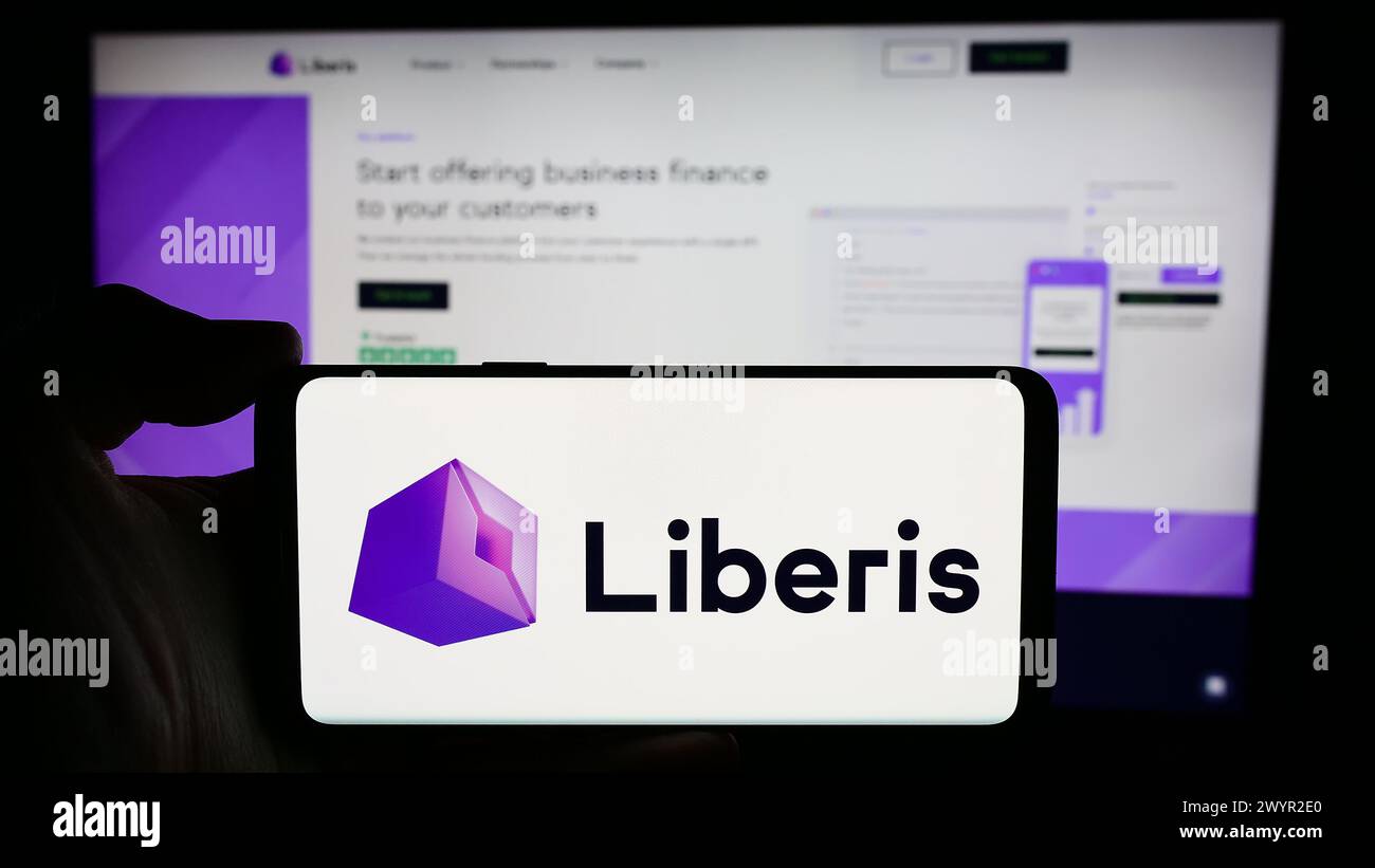 Person holding mobile phone with logo of British financial services ...