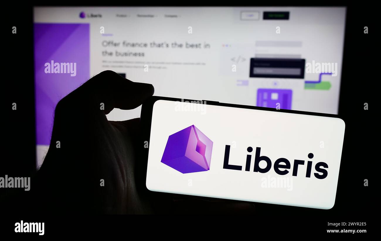 Person holding cellphone with logo of British financial services company Liberis Ltd. in front ...