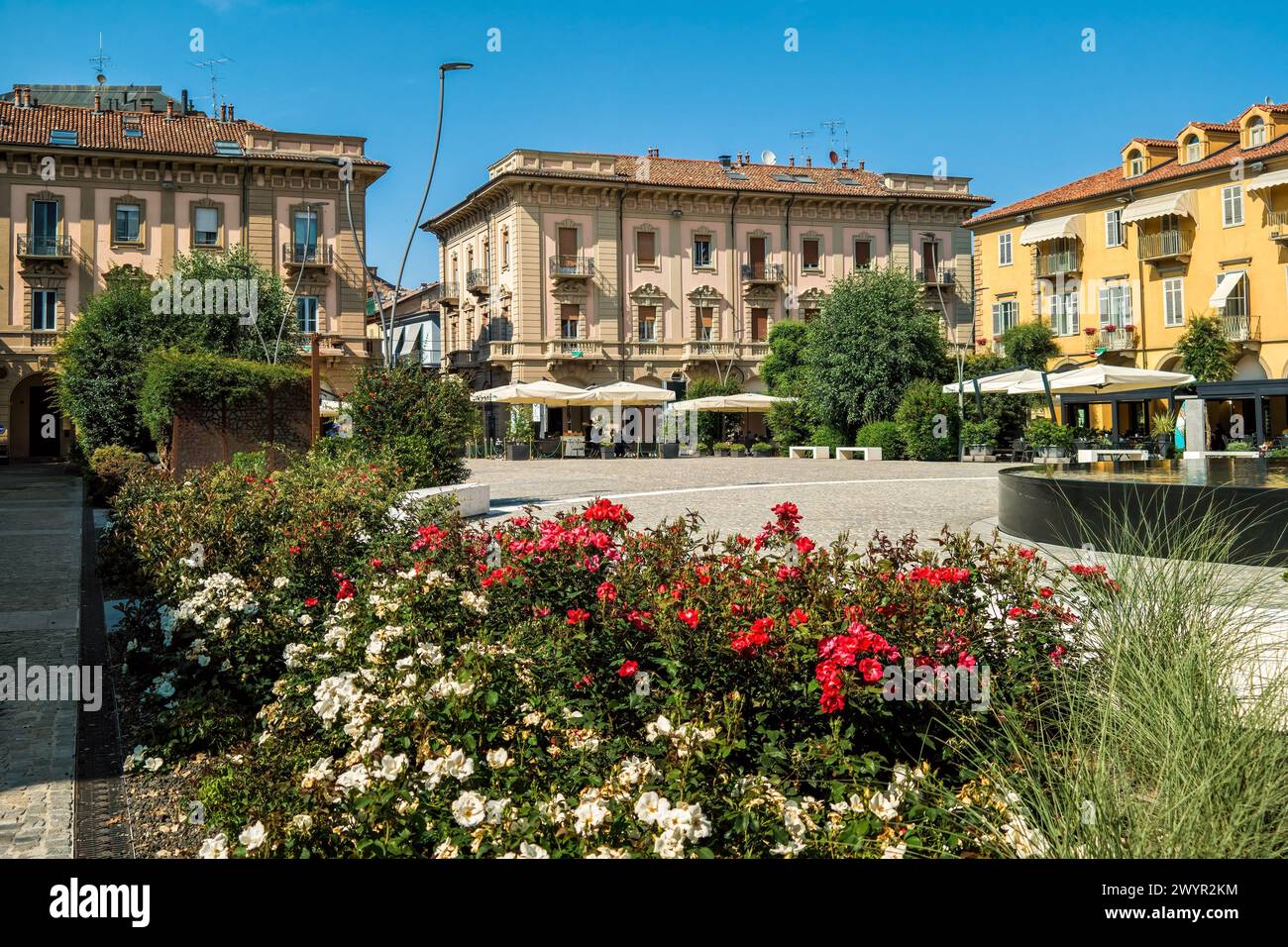 Small cobblestone town square among buildings and flowers in Alba ...