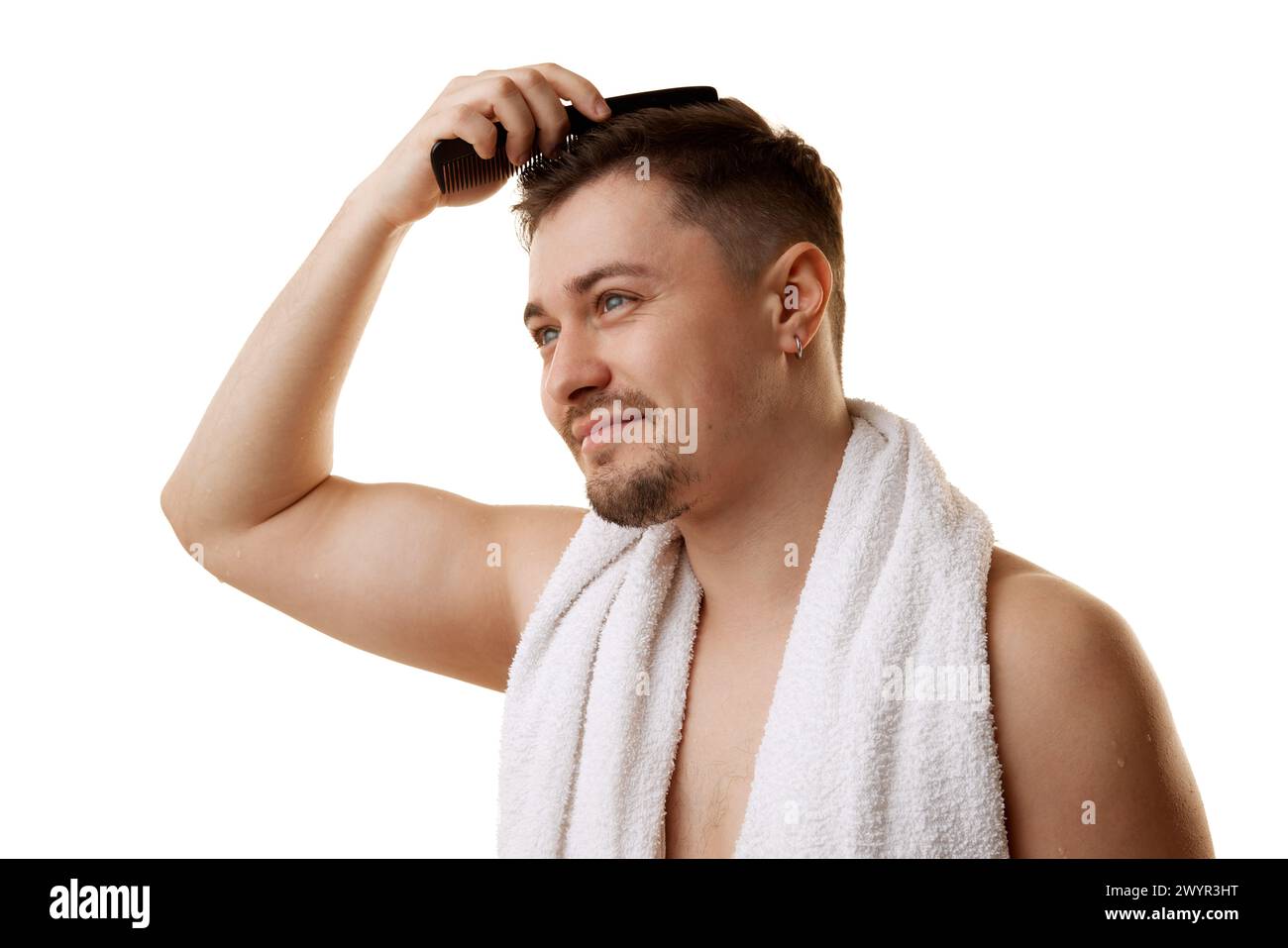 Portrait of man styles his hair with comb after shower looking at ...