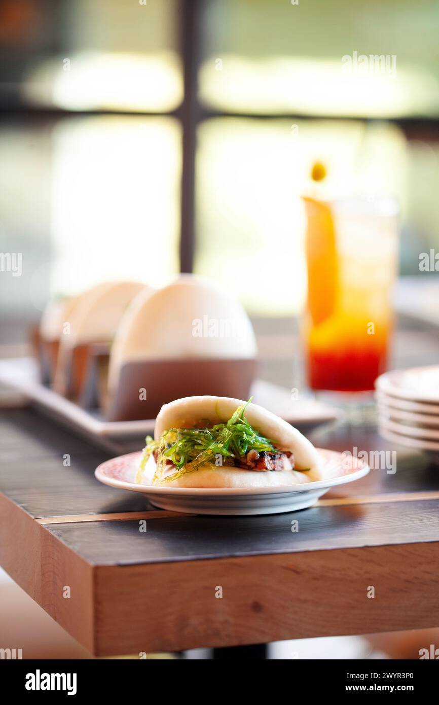 Pork belly bao bun on a small plate vertical Stock Photo - Alamy