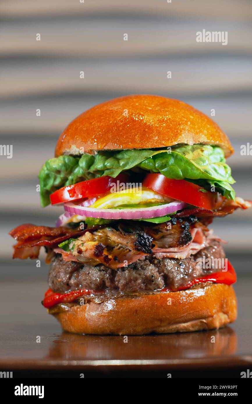 Big burger stacked with meat Stock Photo - Alamy