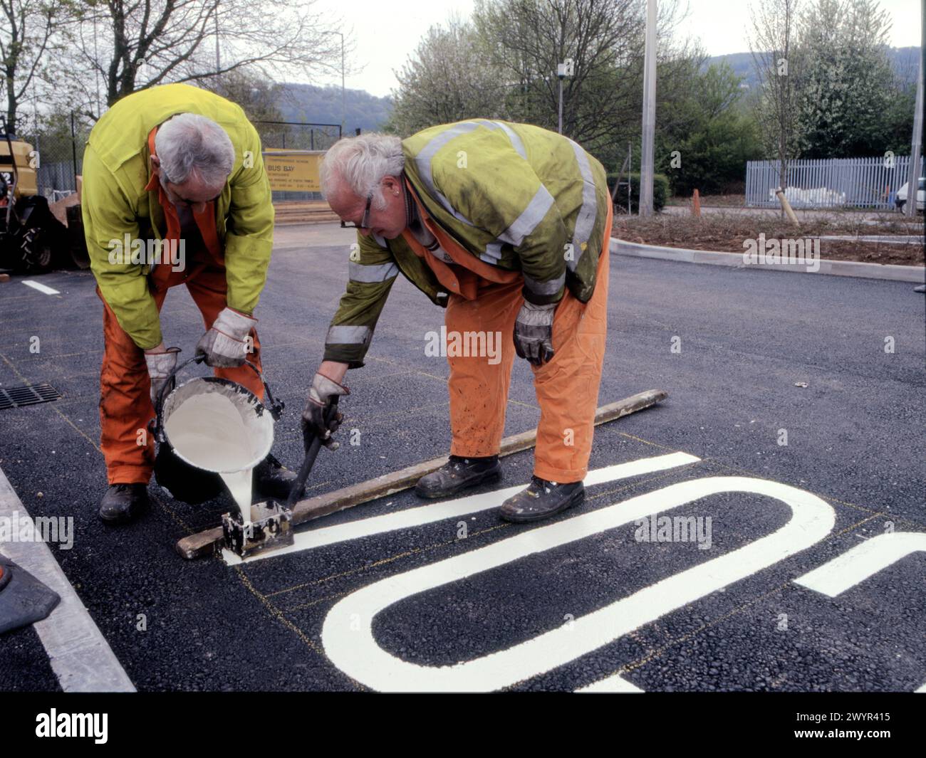 Painting road markings on road surface in car park Stock Photo - Alamy
