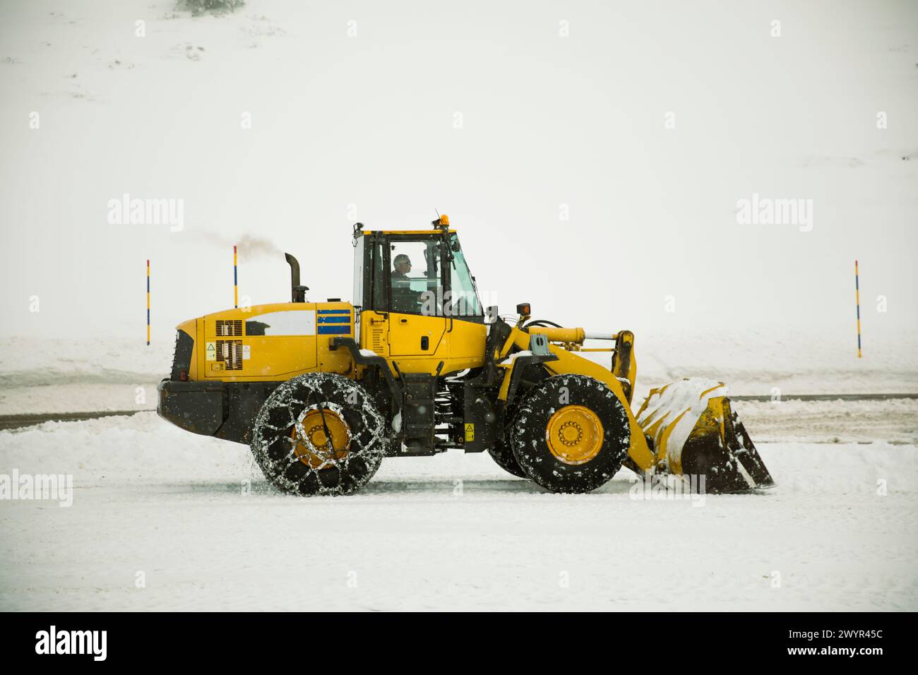 Snow plow clearing a road during a snowy day Stock Photo - Alamy