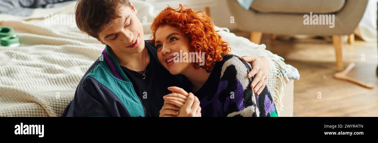 good looking joyous boyfriend and girlfriend hugging warmly while at ...
