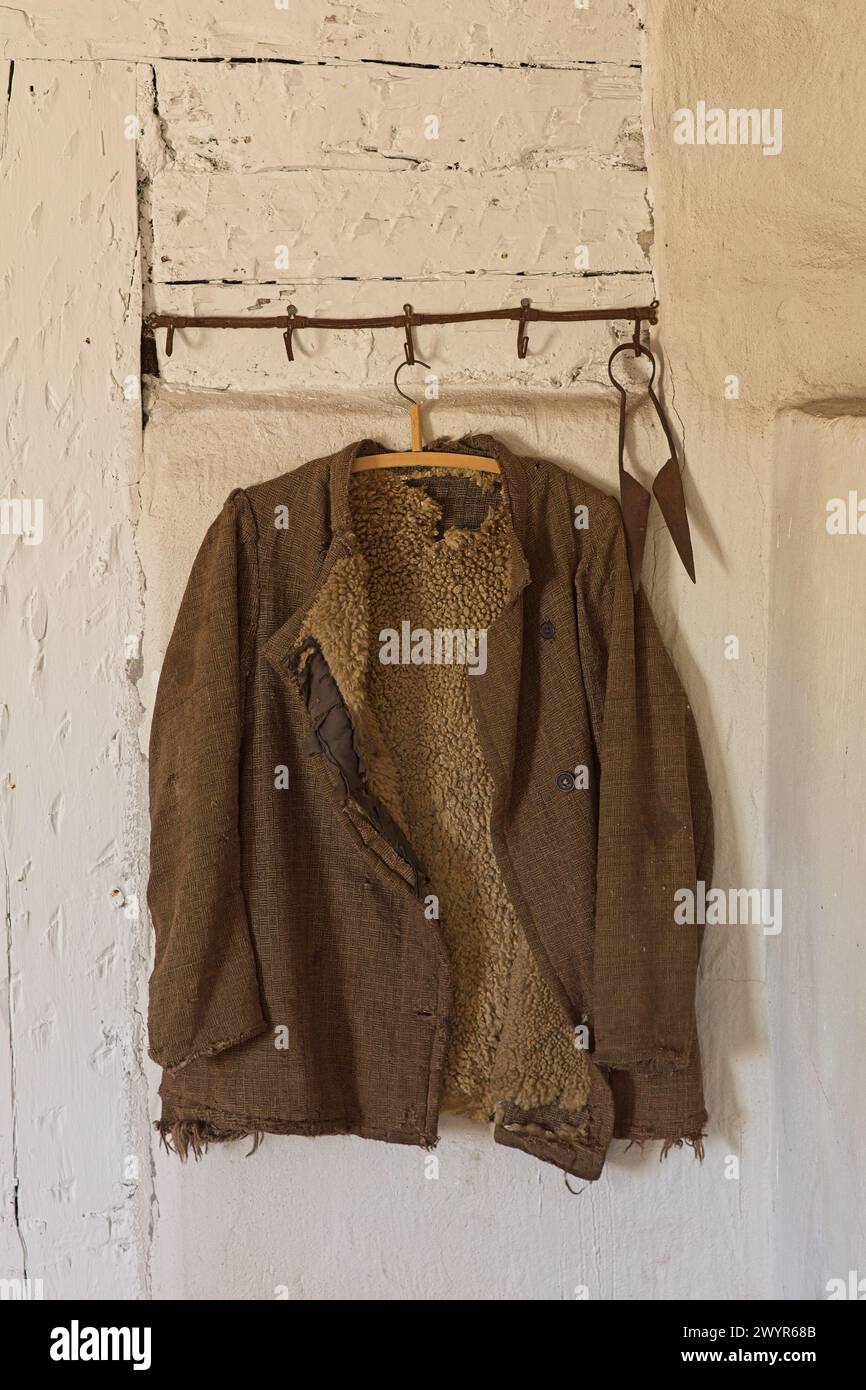 Old jacket on hanger and scissors hanging on a antique metal clothes ...