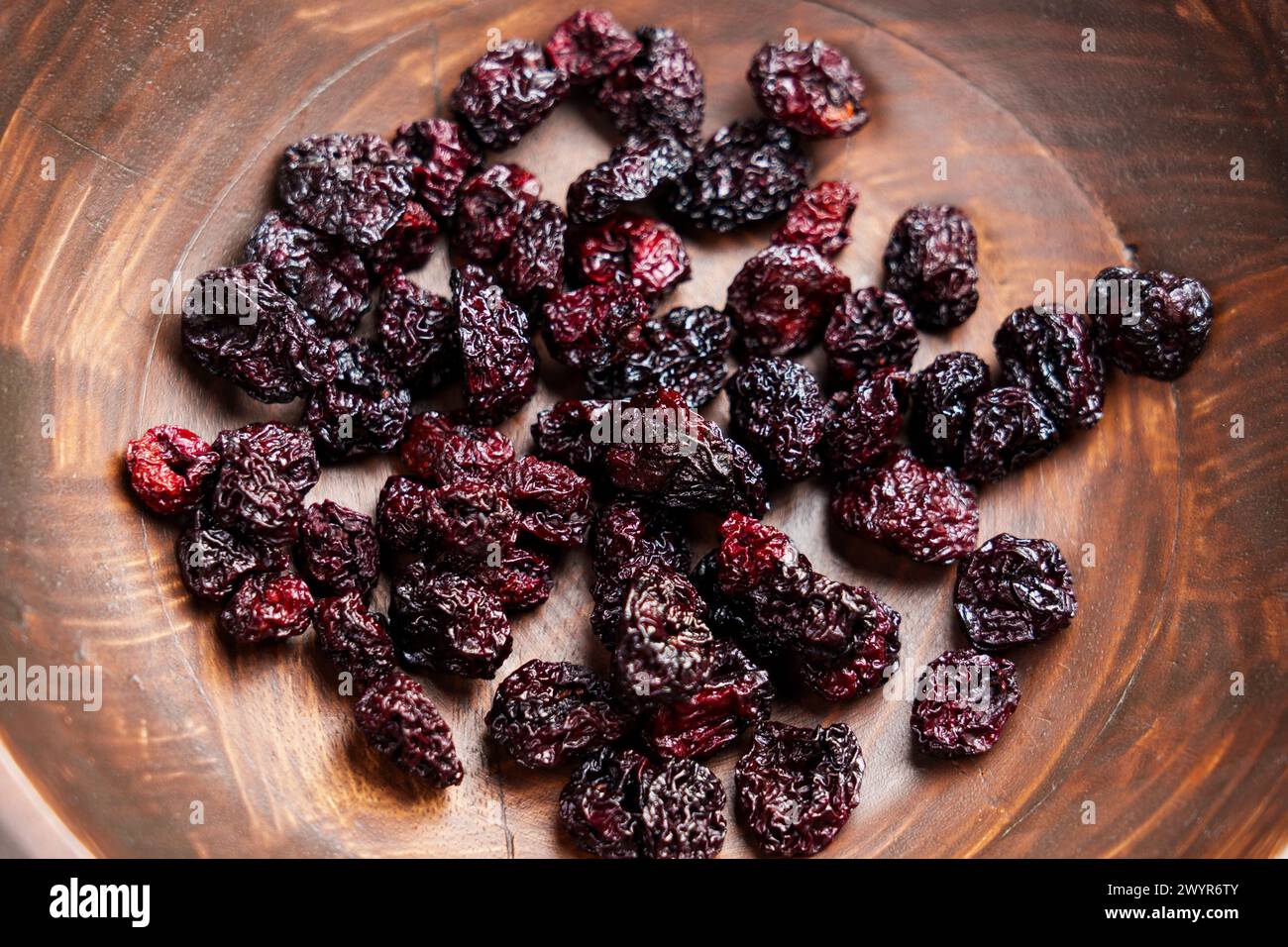 Sweet dry cherry in rustic wooden dish close up. Nutritious dried ...