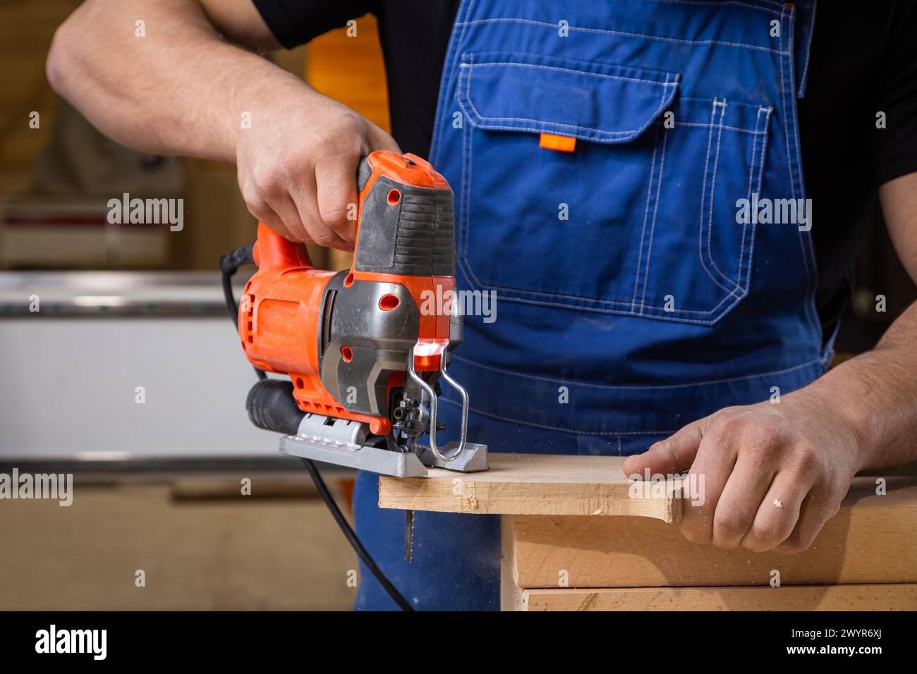 A carpenter using a jigsaw to cut wood cuts bars Stock Photo - Alamy