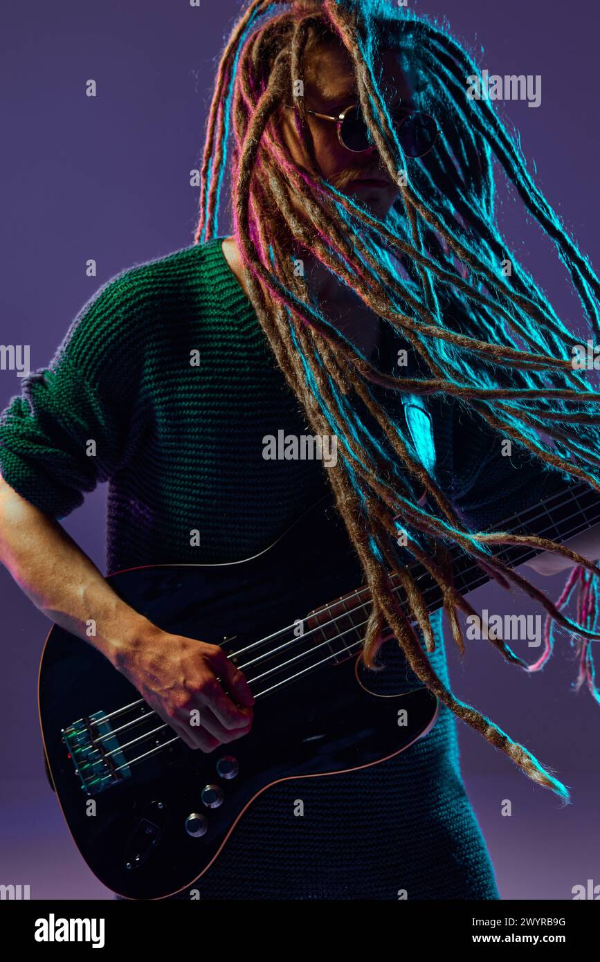 Portrait of stylish guy with dreadlocks, musician playing guitar ...