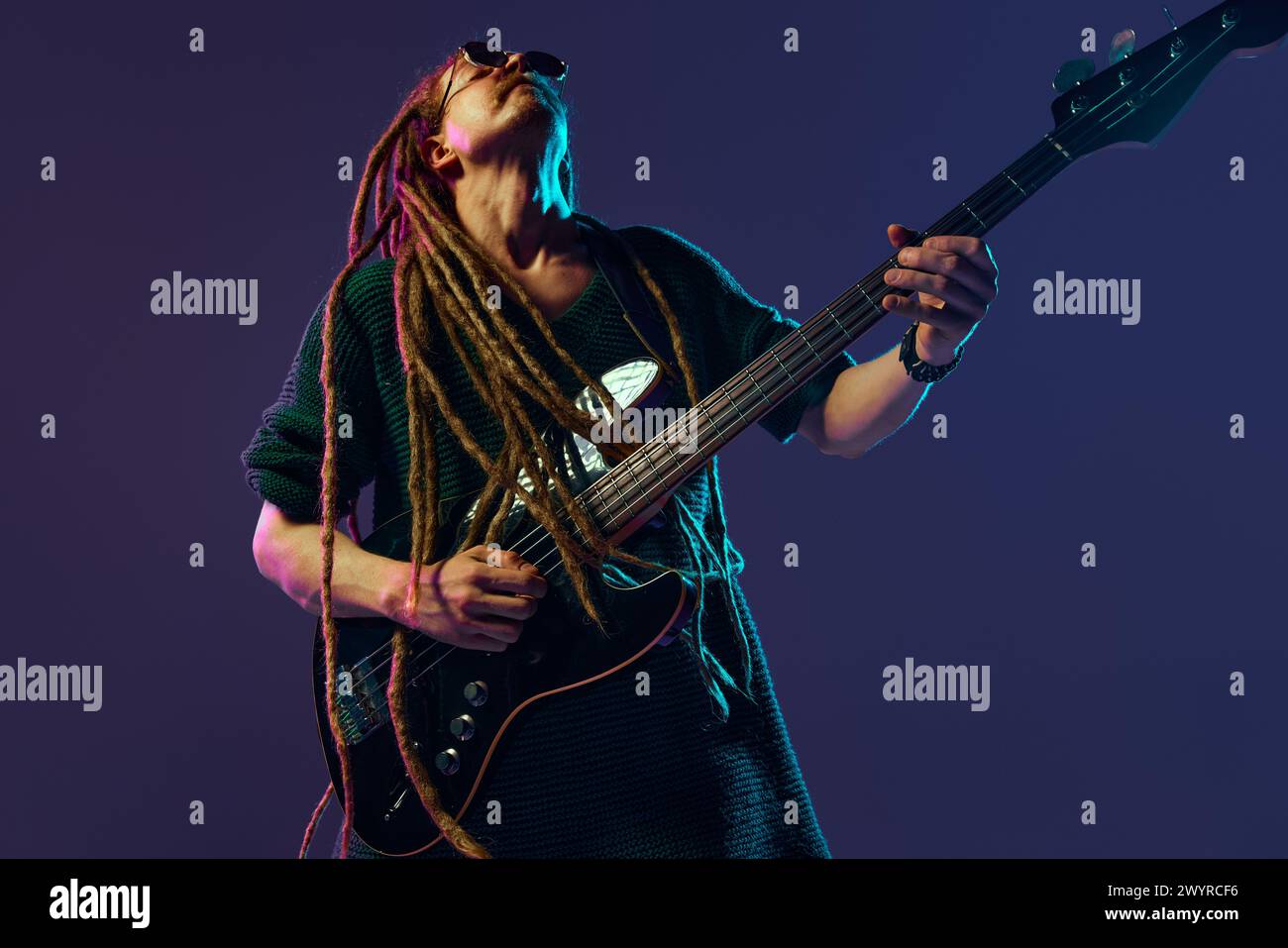 Charismatic guitarist with dreadlocks, musician emotionally playing ...