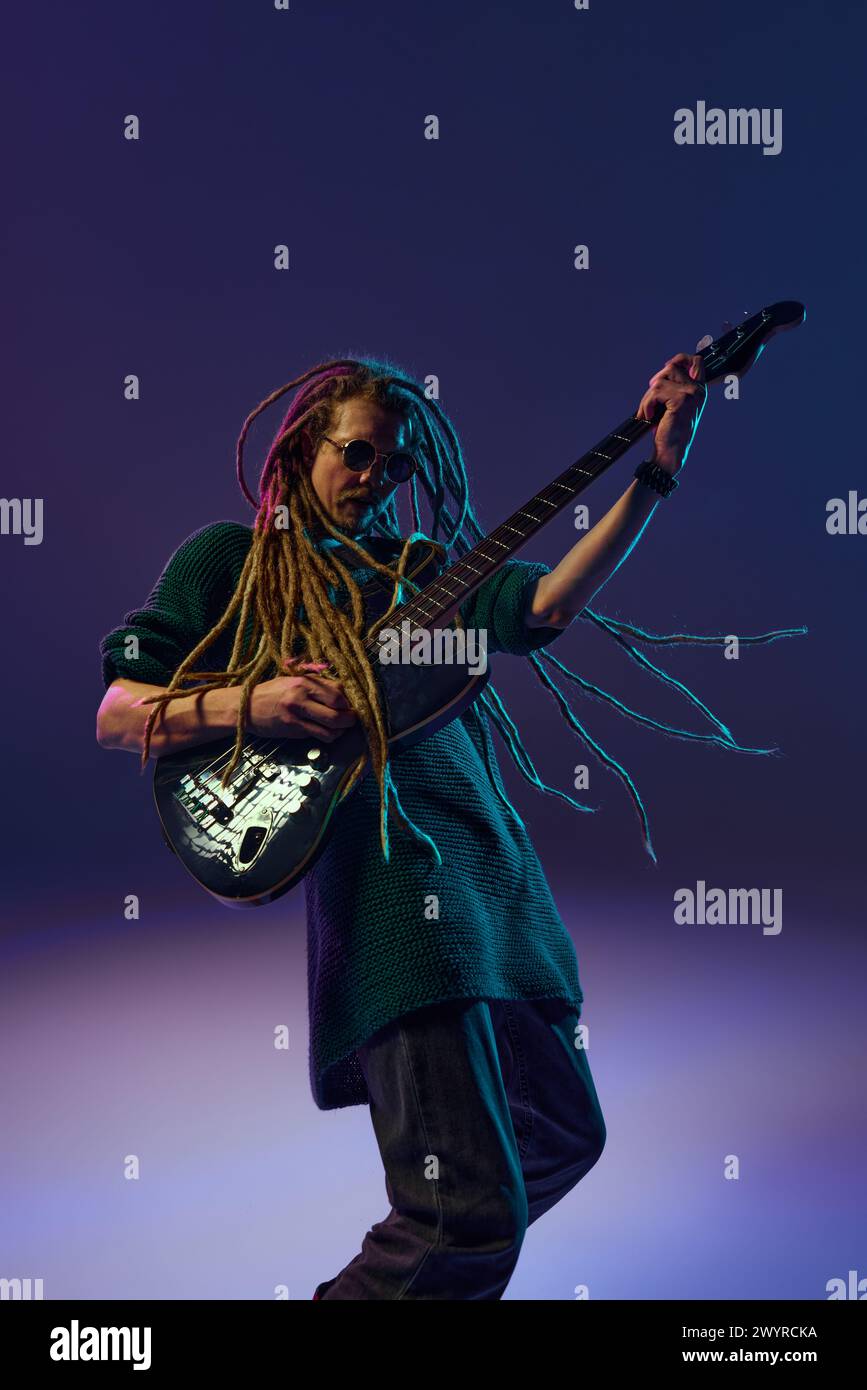 Soulful musician, charismatic guitarist with dreadlocks playing guitar ...