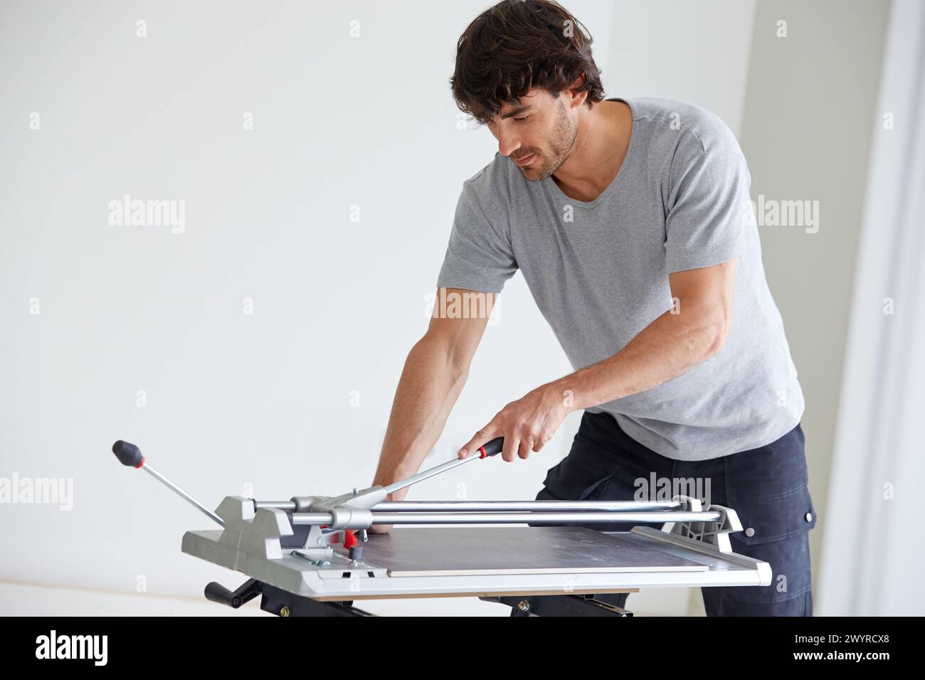 Bricklayer cutting tiles. Construction of apartment houses Stock Photo ...