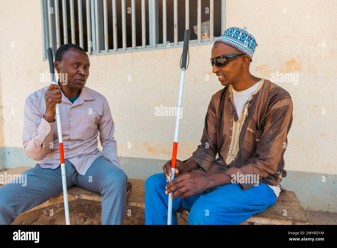 Two blind men sitting on a bench are having a conversation, friendship ...