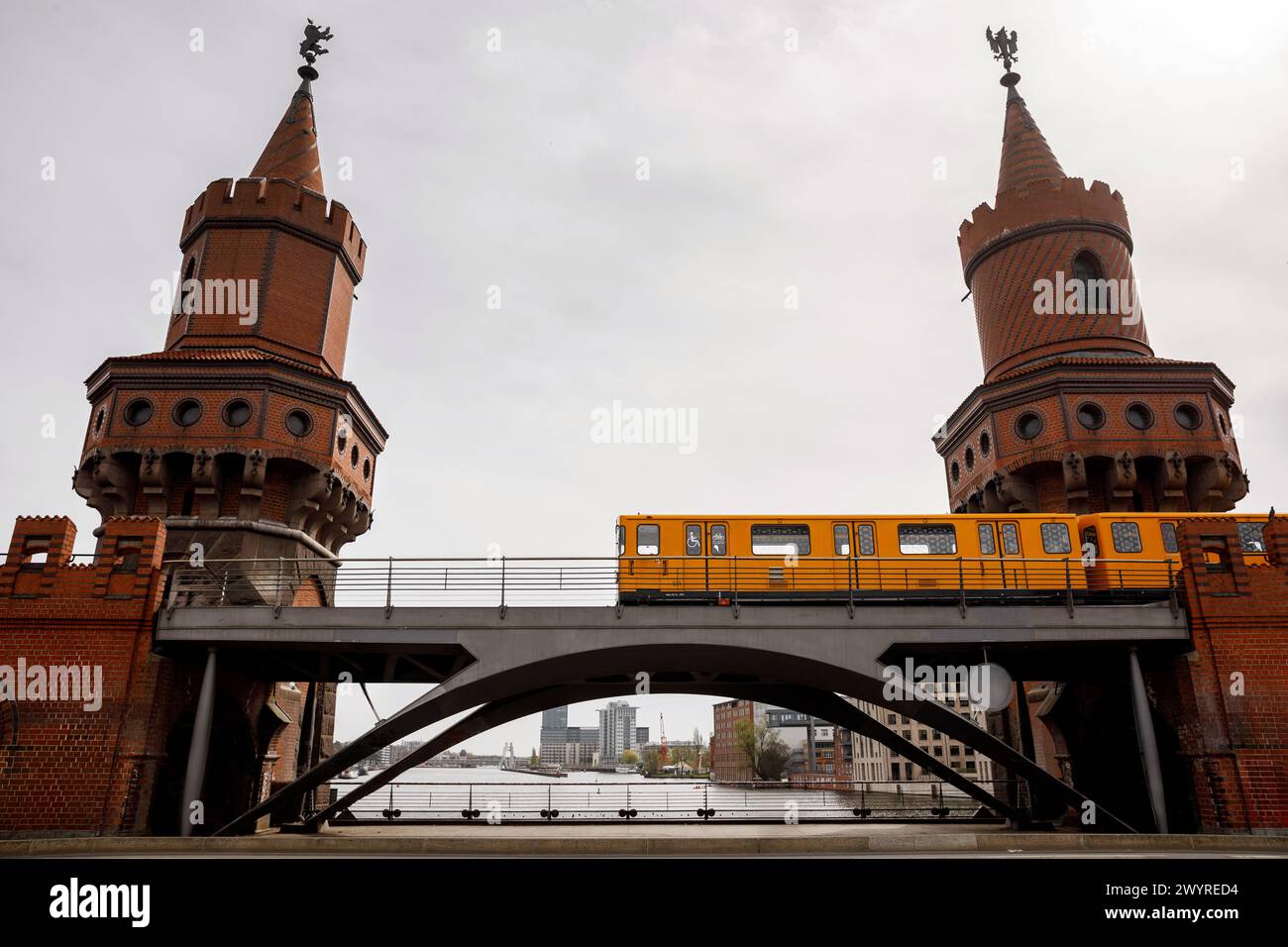 Yellow Berlin metro cars moving along the red brick historic bridge ...