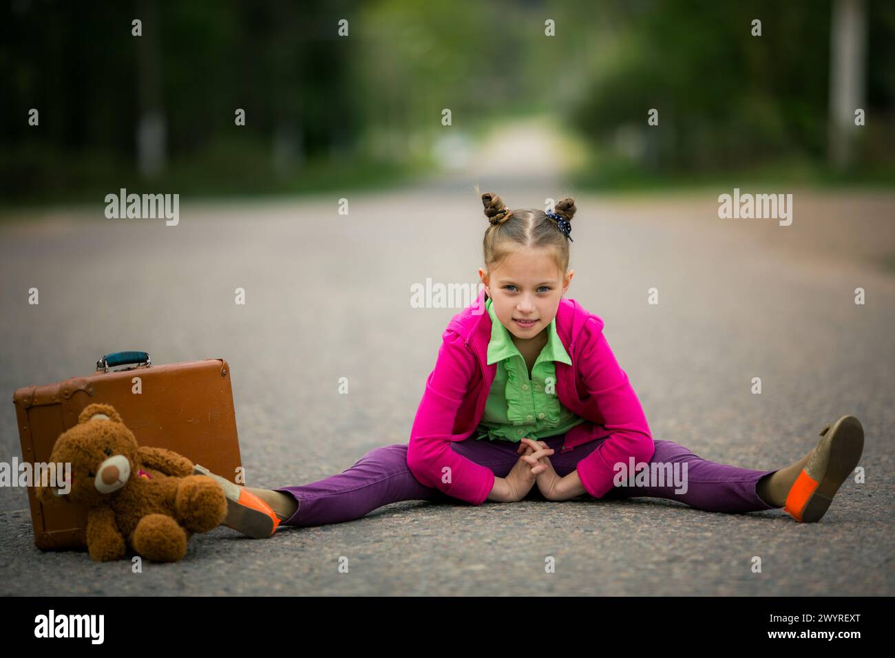 Bright Journey. A young girl in vibrant attire stands on the road with ...