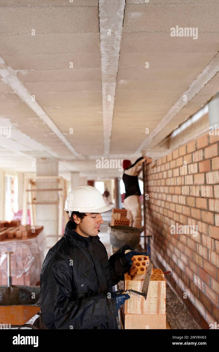 Bricklayer, bricking up a partition wall, new homes under construction ...