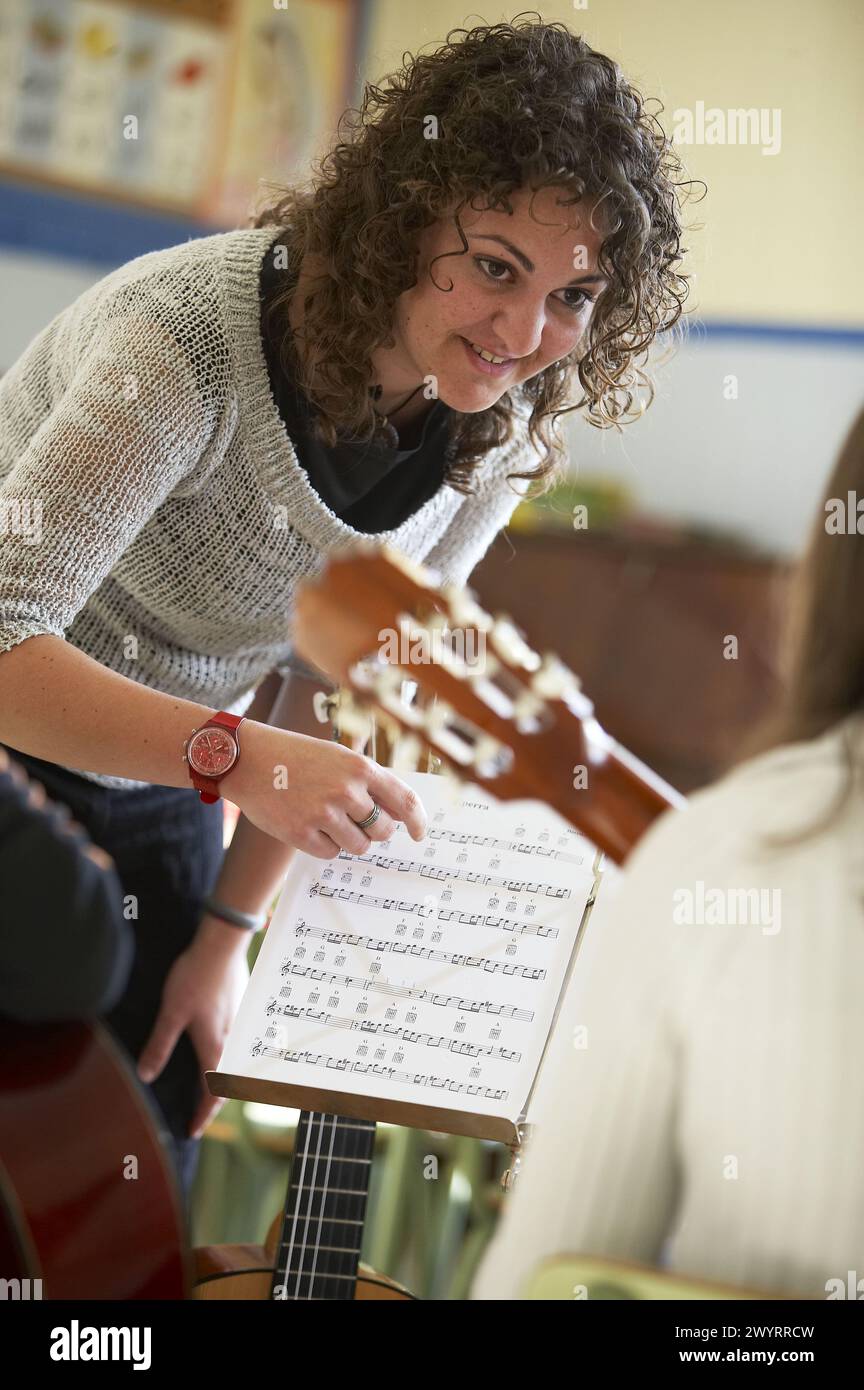 Teacher playing guitar with students hi-res stock photography and ...