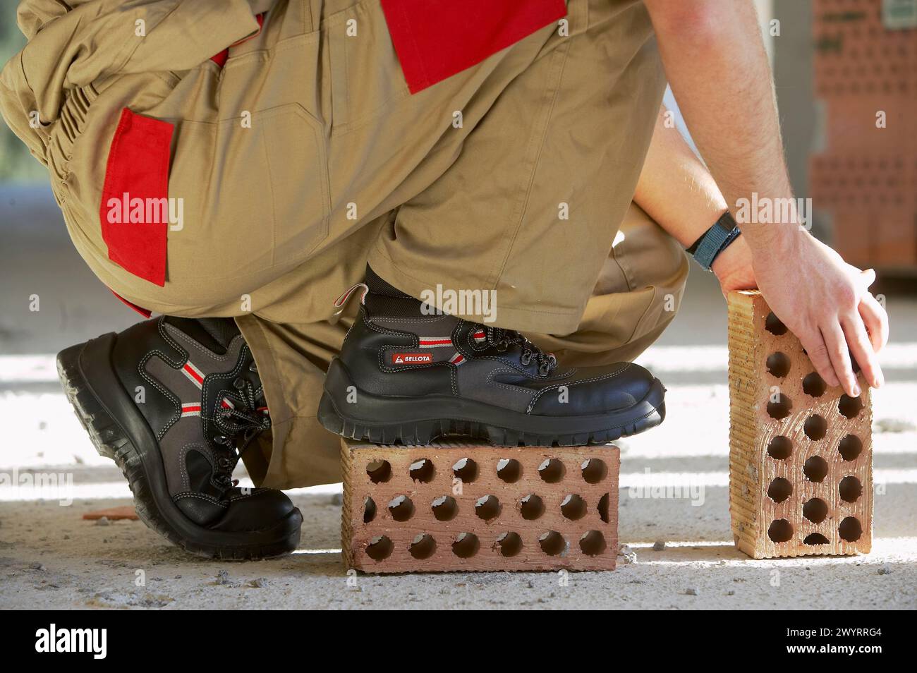 Bricklayer with safety boots, bricks, housing construction Stock Photo ...