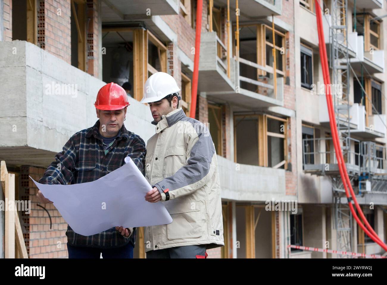 Workers with blueprints. Building construction Stock Photo - Alamy