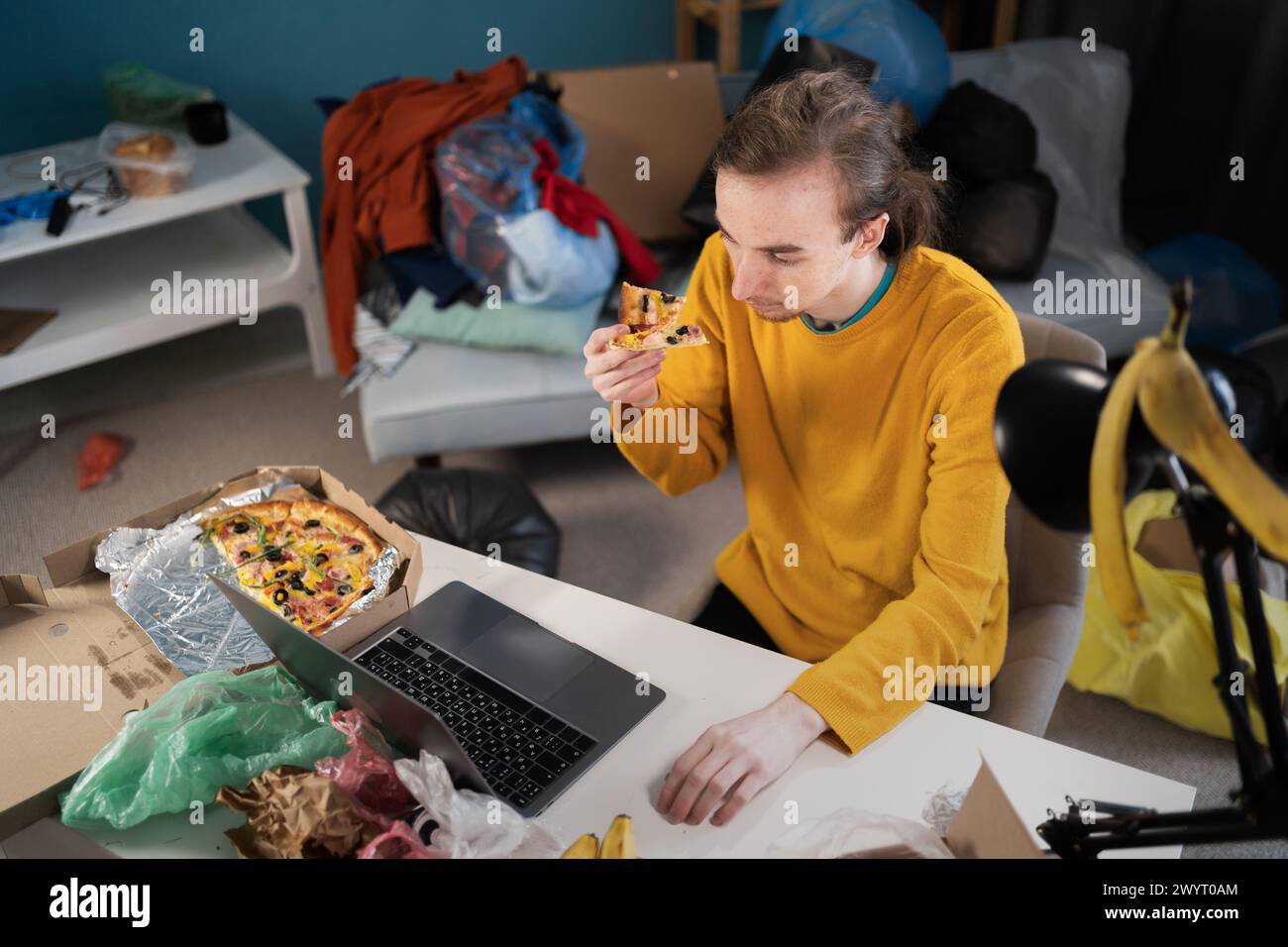 Student or freelancer working and studying in very messy, cluttered ...