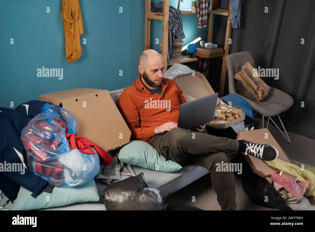 Serious millennial man working studying in messy room Stock Photo - Alamy