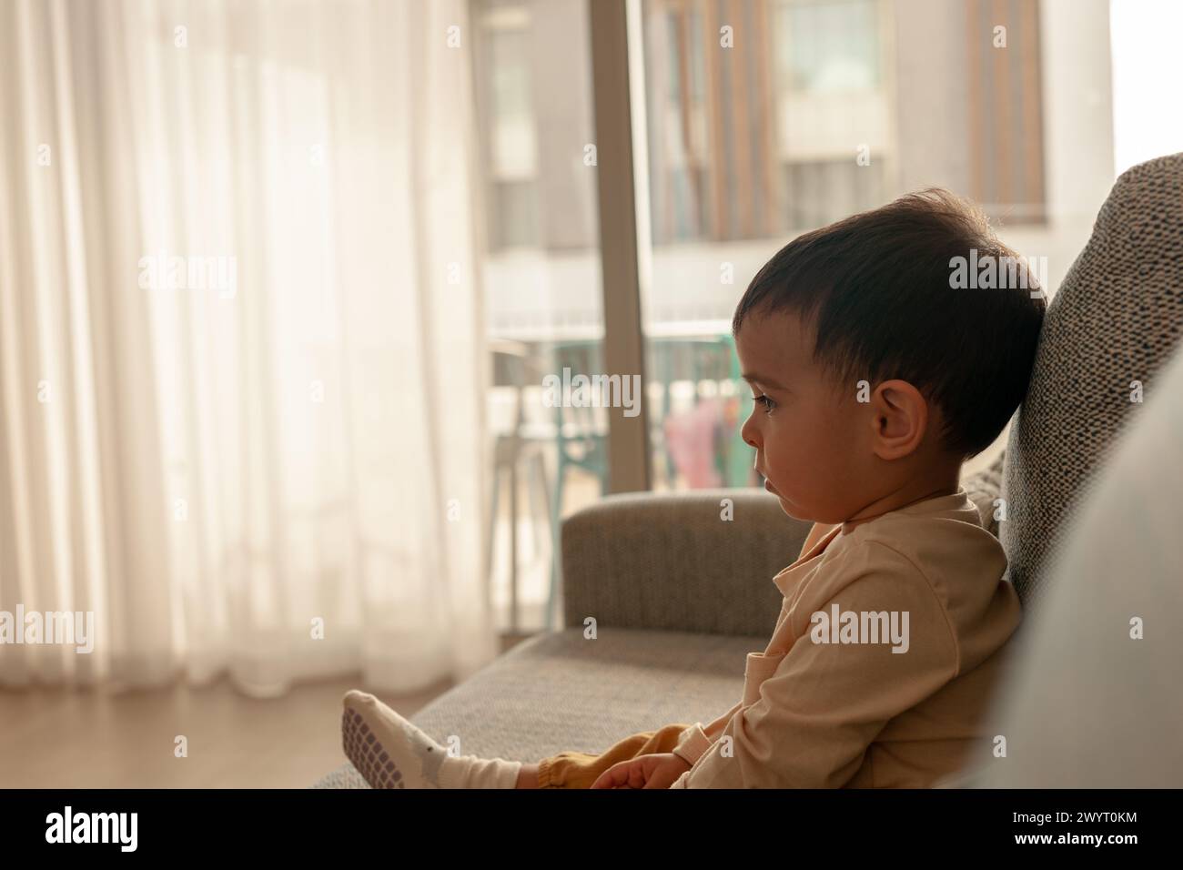 Baby watching television on the sofa at home Stock Photo - Alamy
