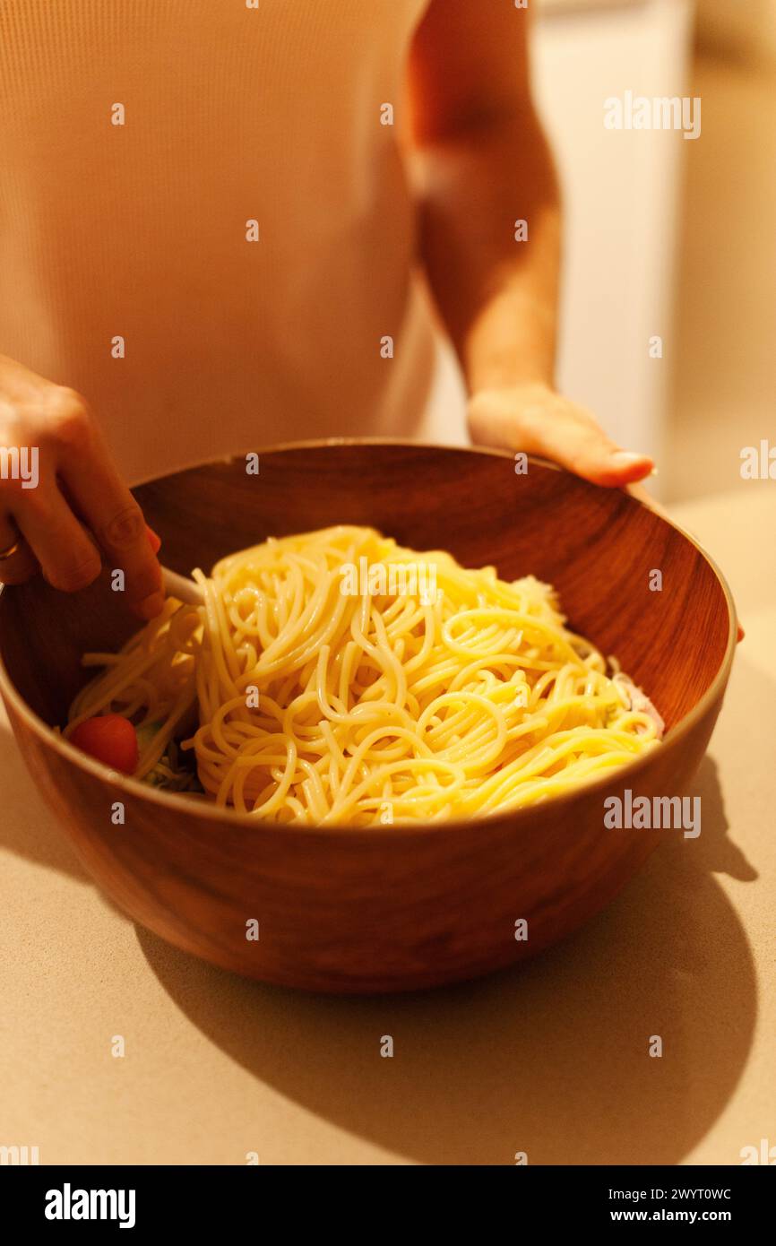 Woman's hands mixing pasta salad Stock Photo - Alamy