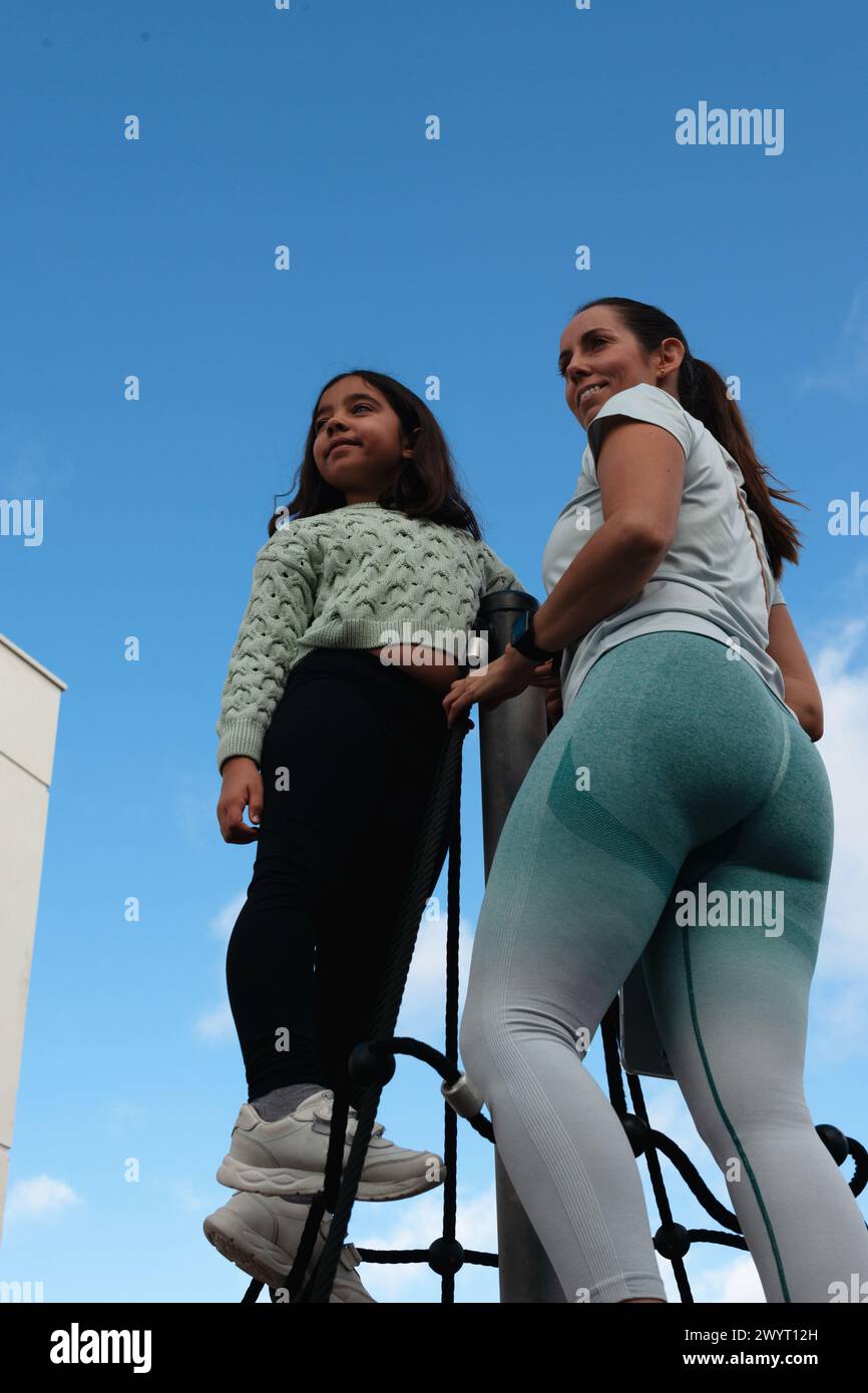 Mother and daughter gazing into infinity from the top of the swing ...