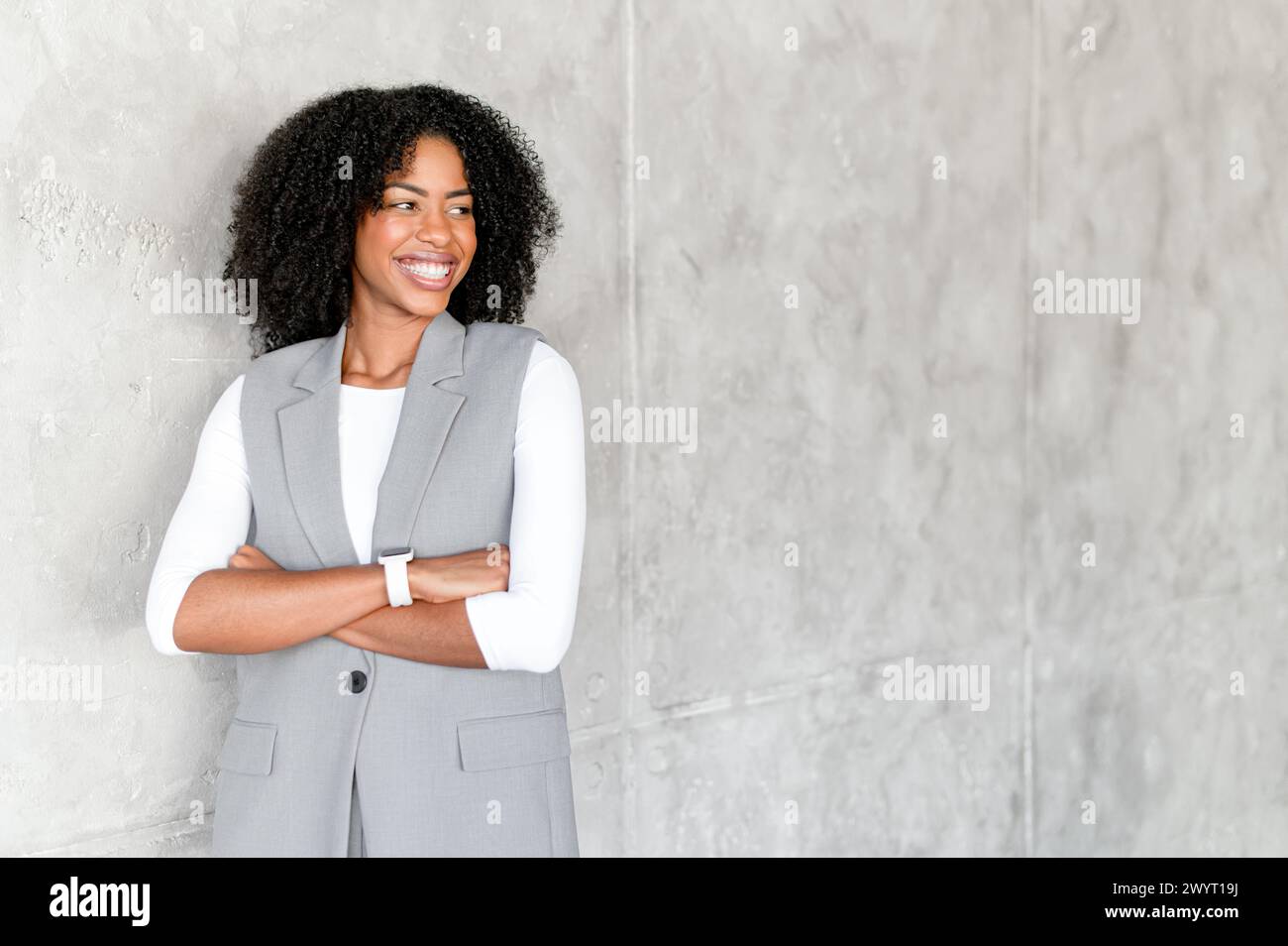 The businesswoman stands with her arms confidently at her sides, a ...