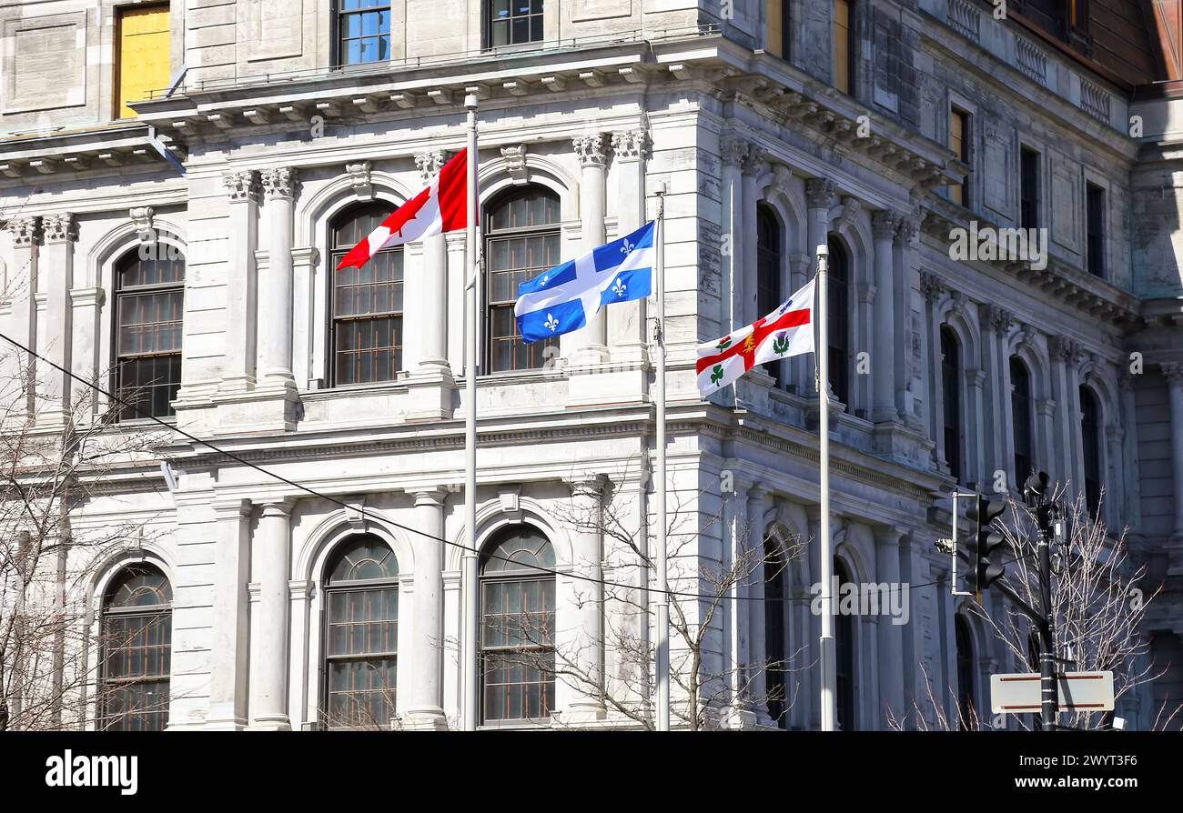 Quebec, Canadian and Montreal flags waving with the foreground of City ...