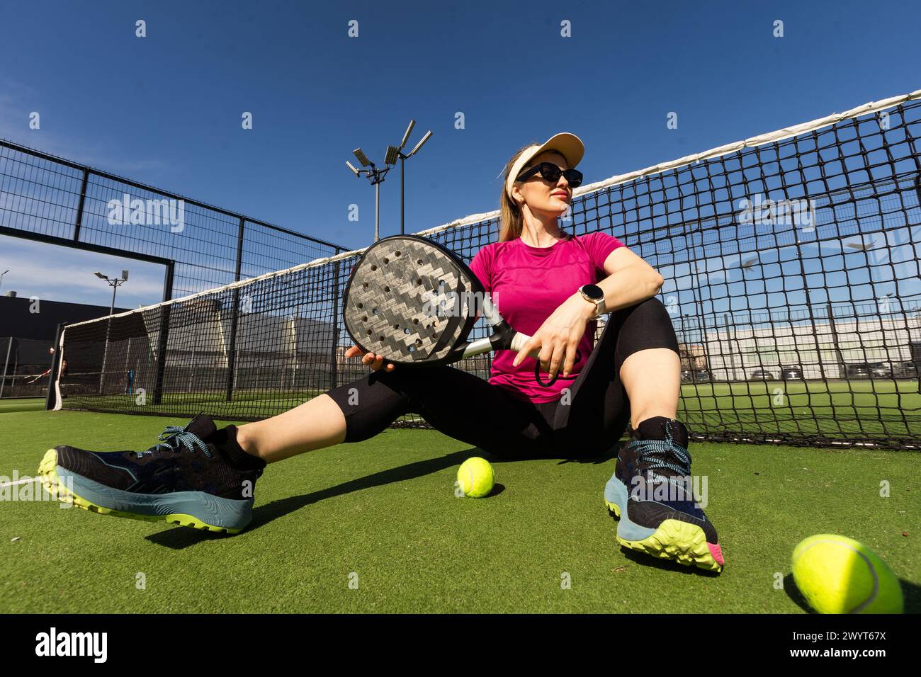 Sporty european woman padel tennis player trains on the outdoor court ...