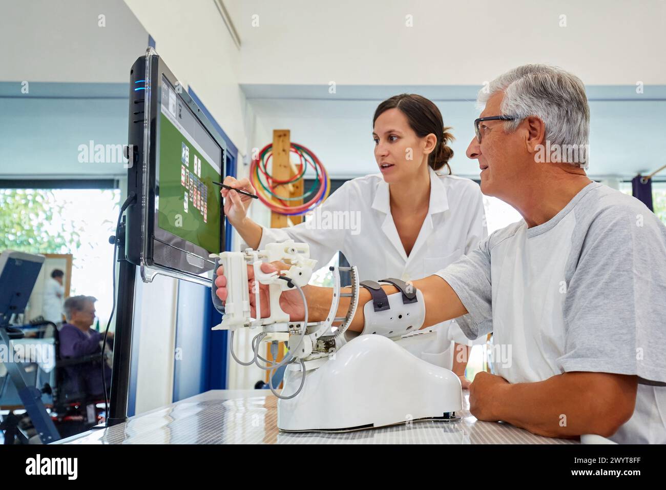 Therapist and patient with assistive robot for upper limb ...