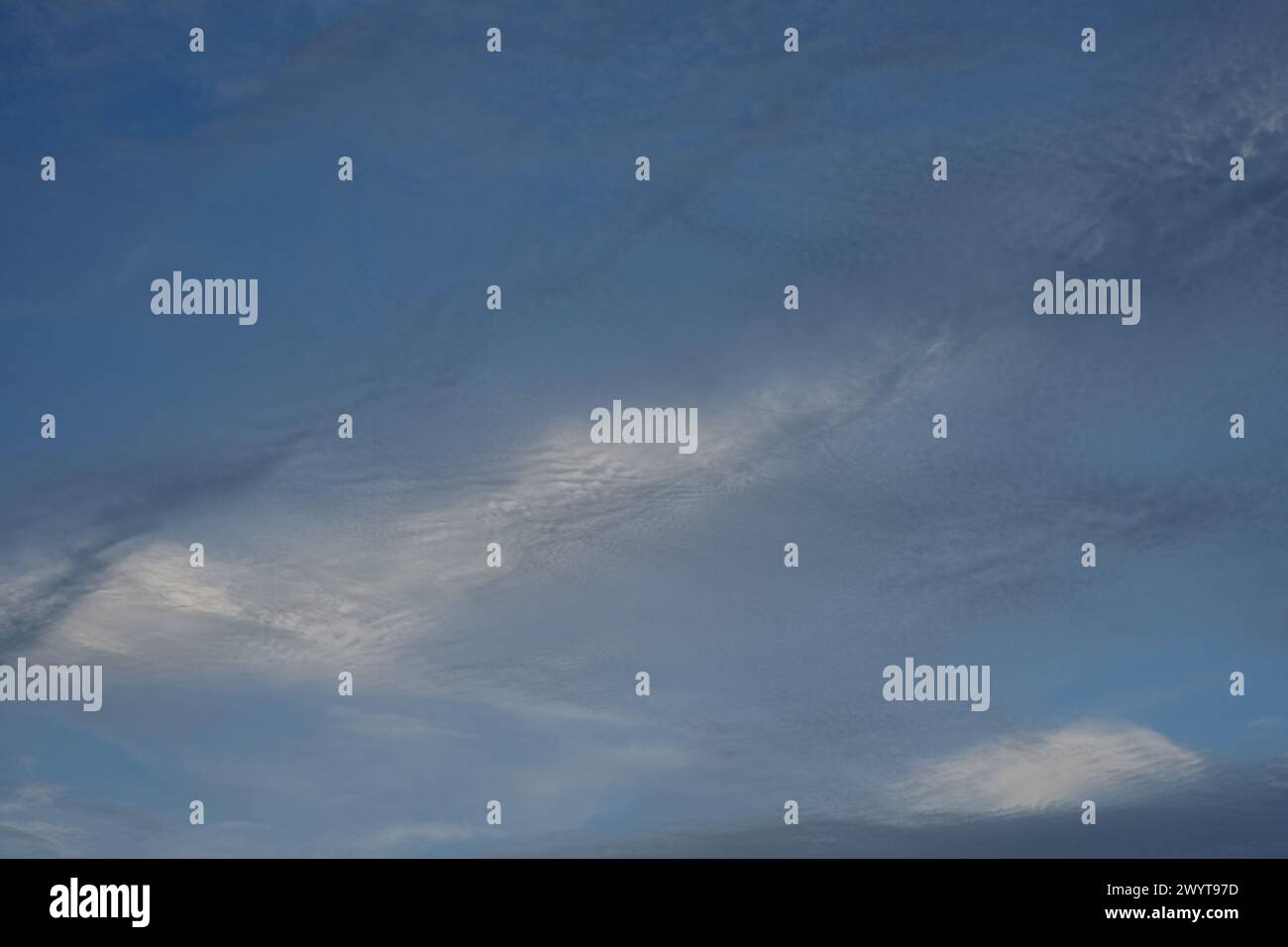 Clouds at different altitudes, lace like wisps of grey cloud below ...