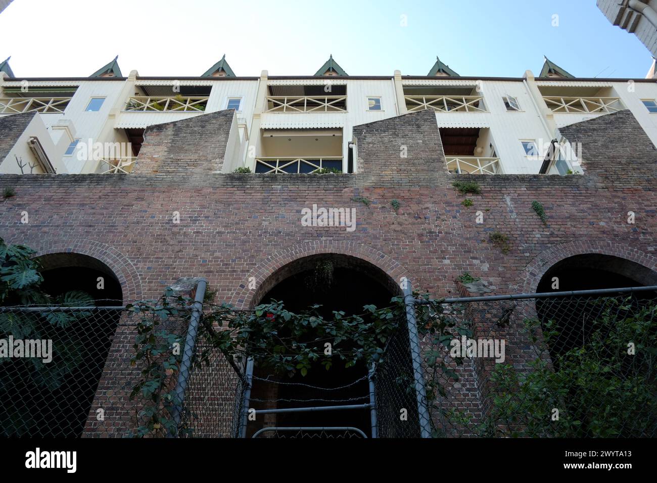 Looking up at the brick wall with tall arches supporting the three ...