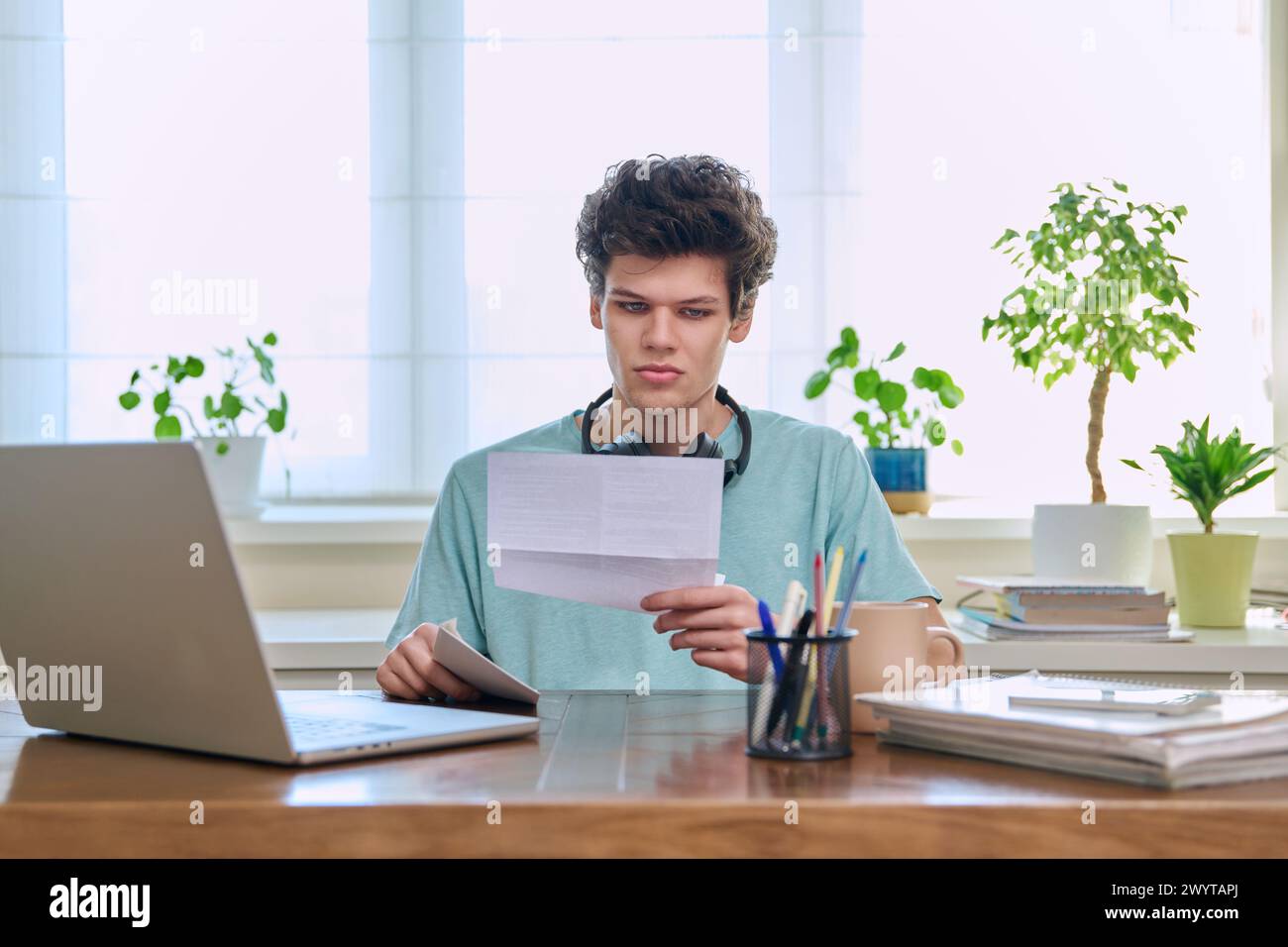 Serious young guy reading letter, paper document Stock Photo - Alamy