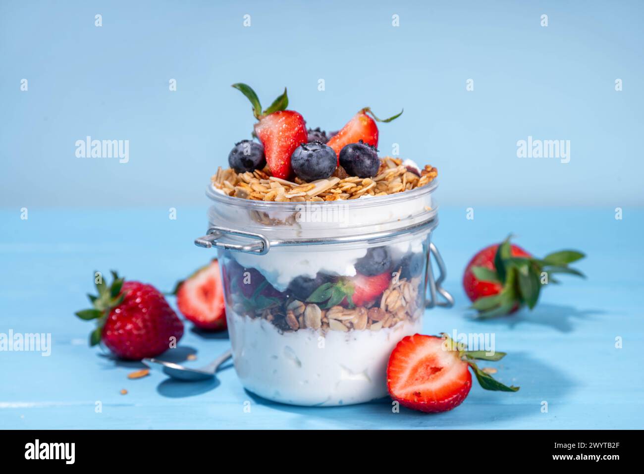 Summer berries granola breakfast layered dessert with yogurt, oat multi ...