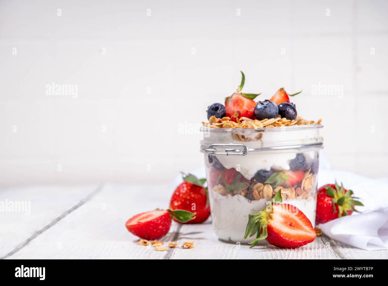 Summer berries granola breakfast layered dessert with yogurt, oat multi ...