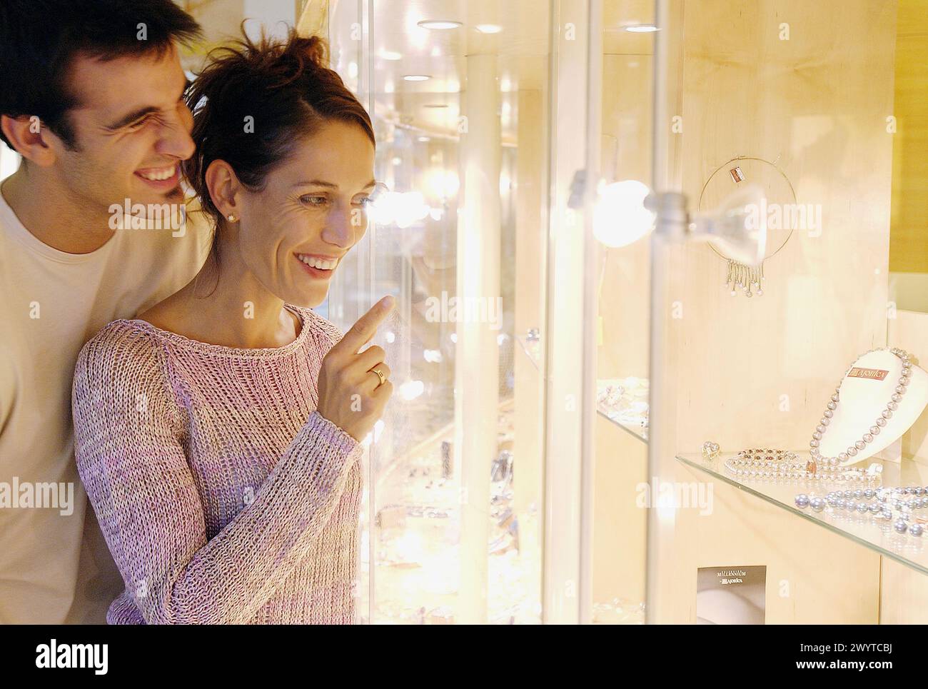 Couple in shopping center, looking at jewelry Stock Photo - Alamy