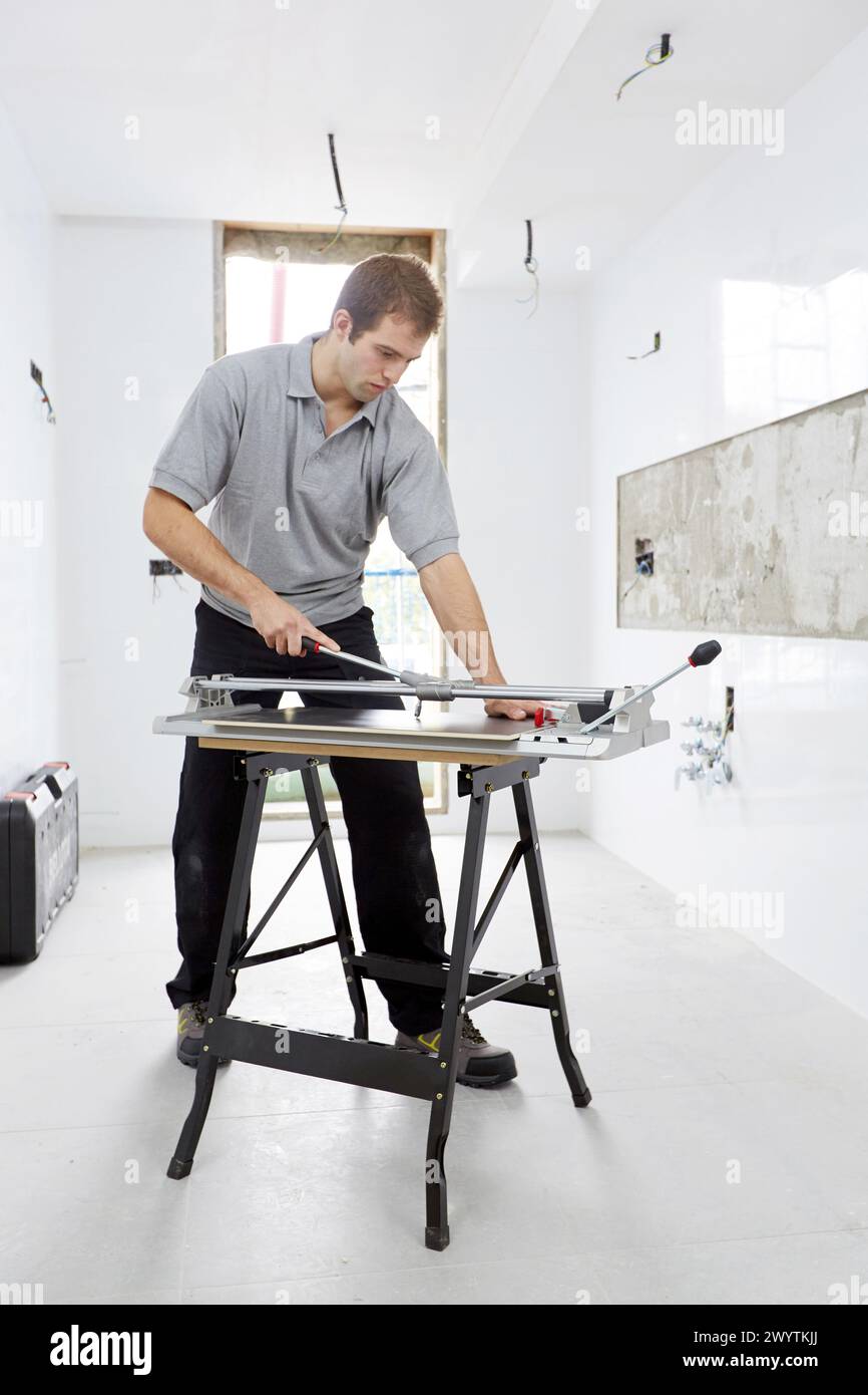 Bricklayer cutting tile. Manual tile cutter. Construction Industry ...