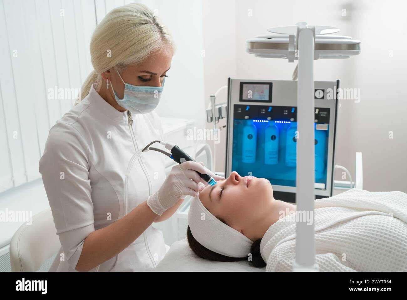 A cosmetologist performs hardware facial skin rejuvenation procedures ...